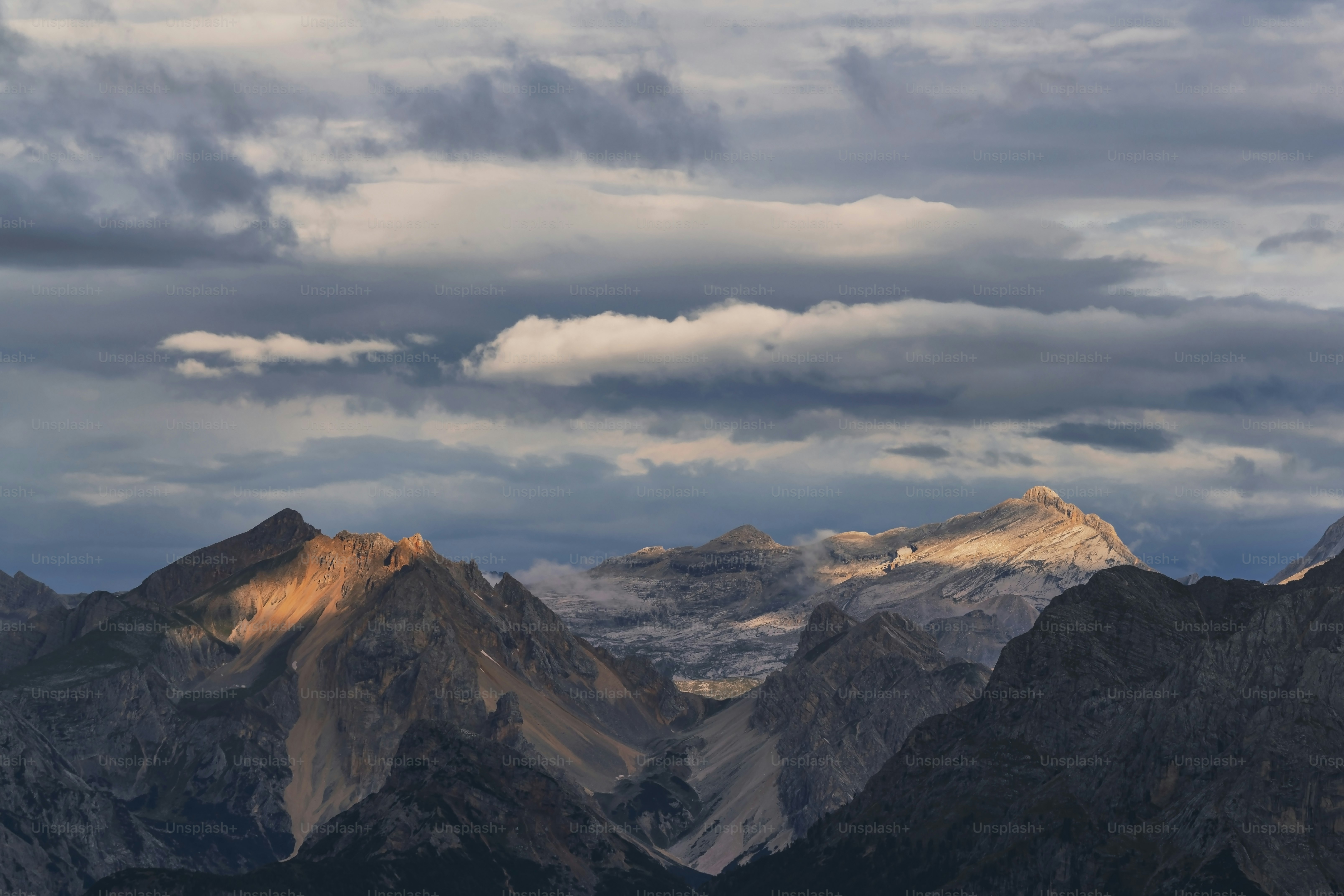 A group of mountains with clouds in the sky photo – Wallpaper Image on ...