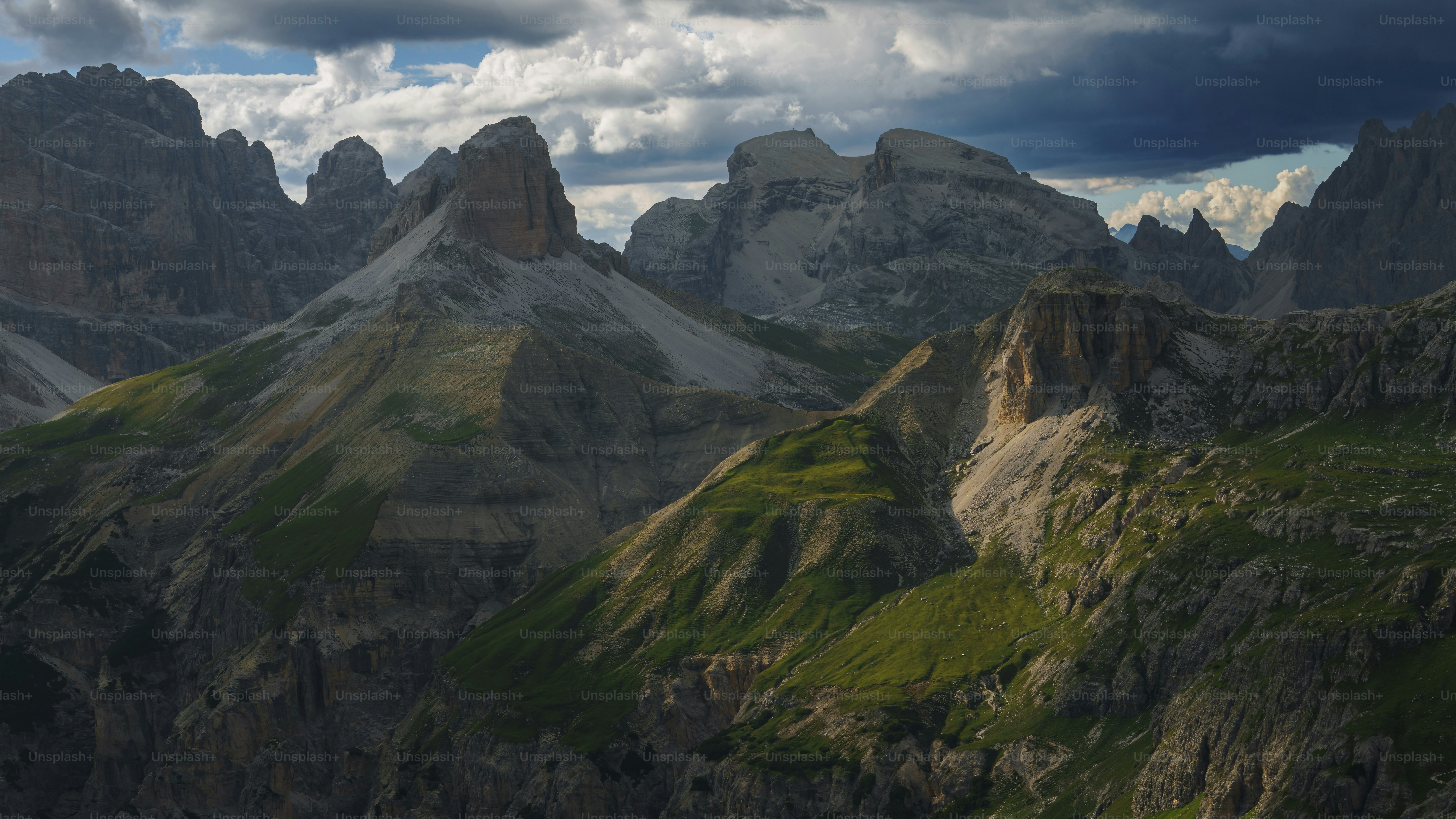 A group of mountains with clouds in the sky photo – Nature Image on ...