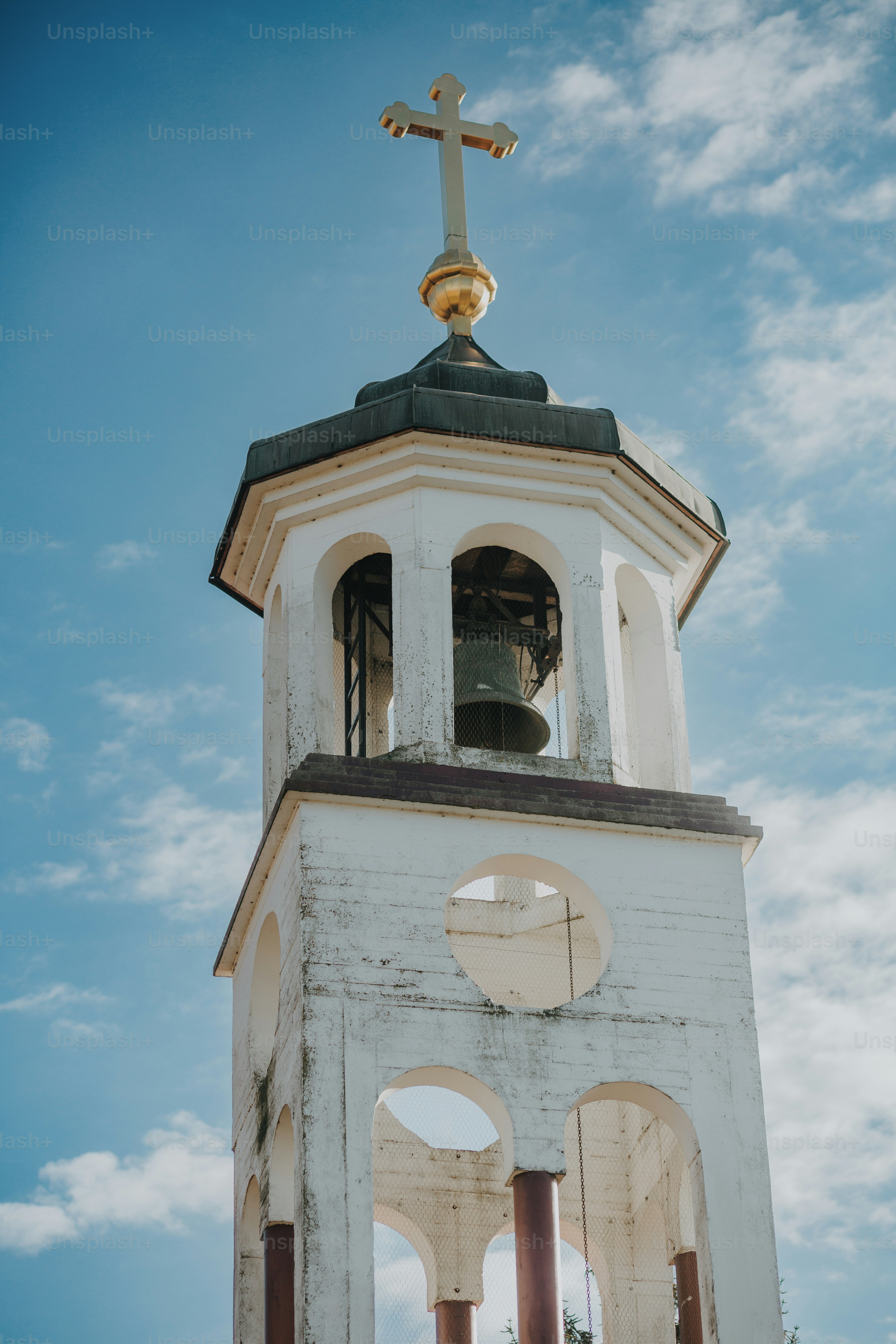 A white church bell tower with a cross on top photo – Clouds Image on ...