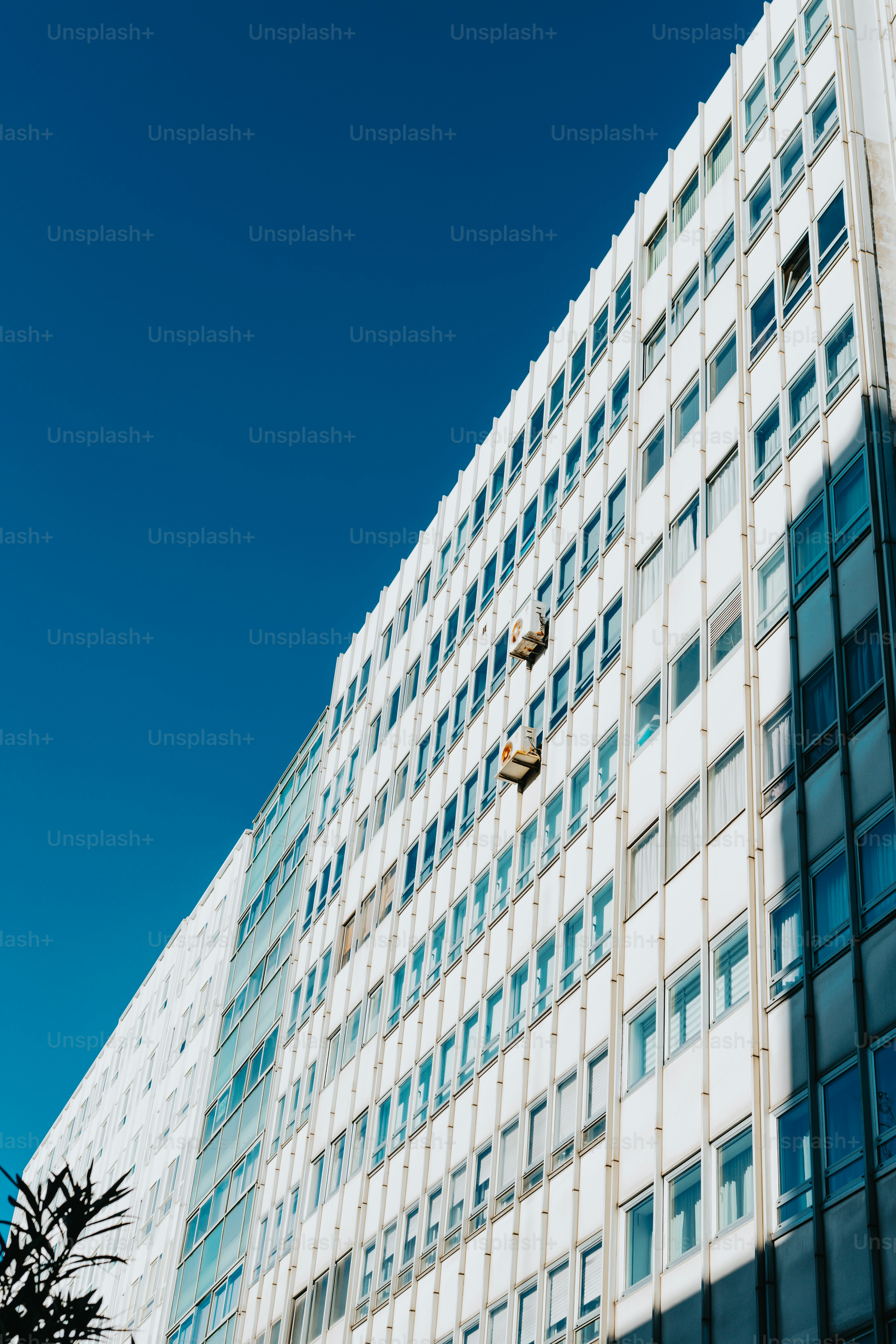 A tall white building with lots of windows photo – Architecture Image ...