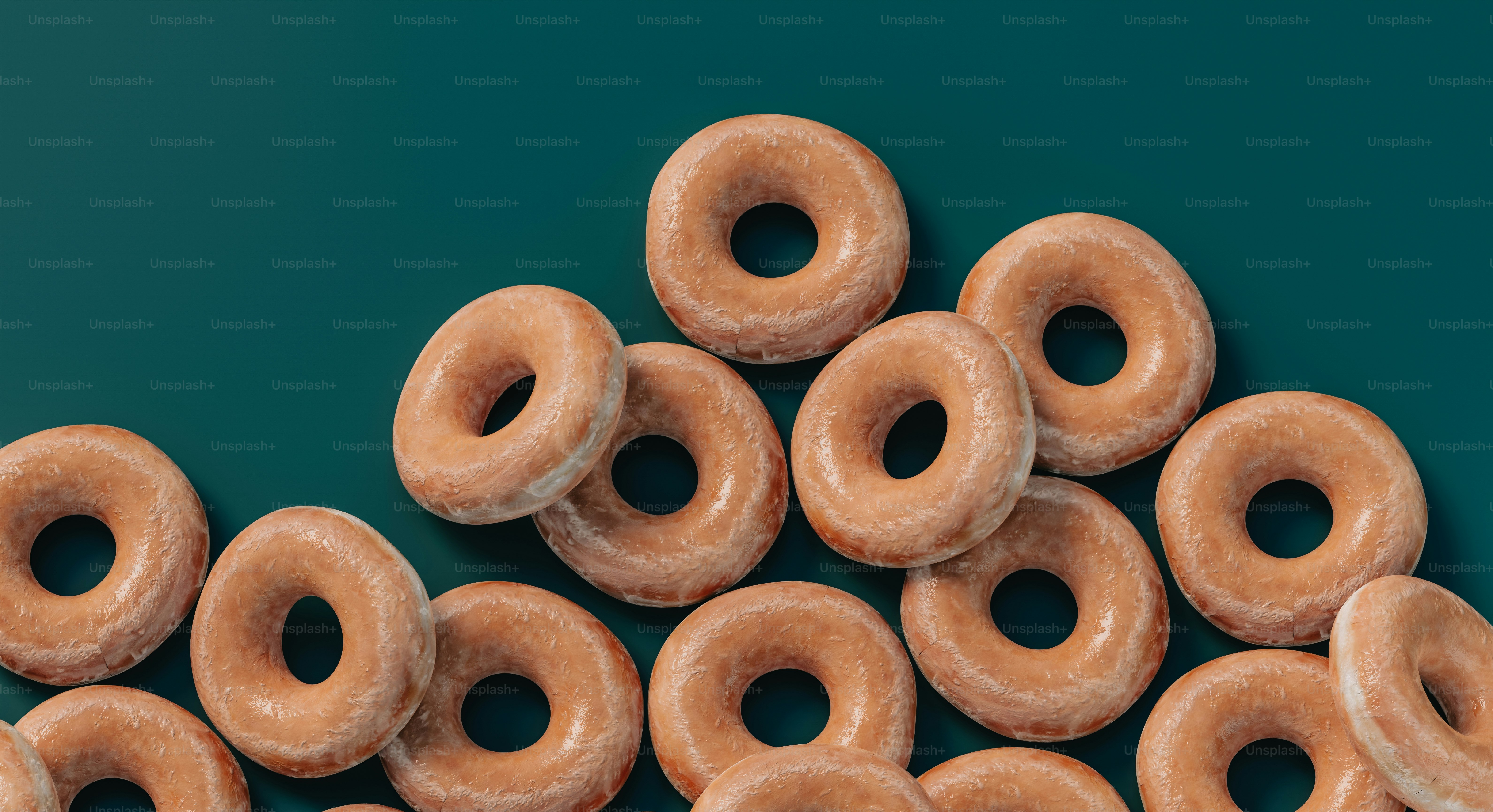 A pile of glazed donuts sitting on top of a table photo – Donut Image ...