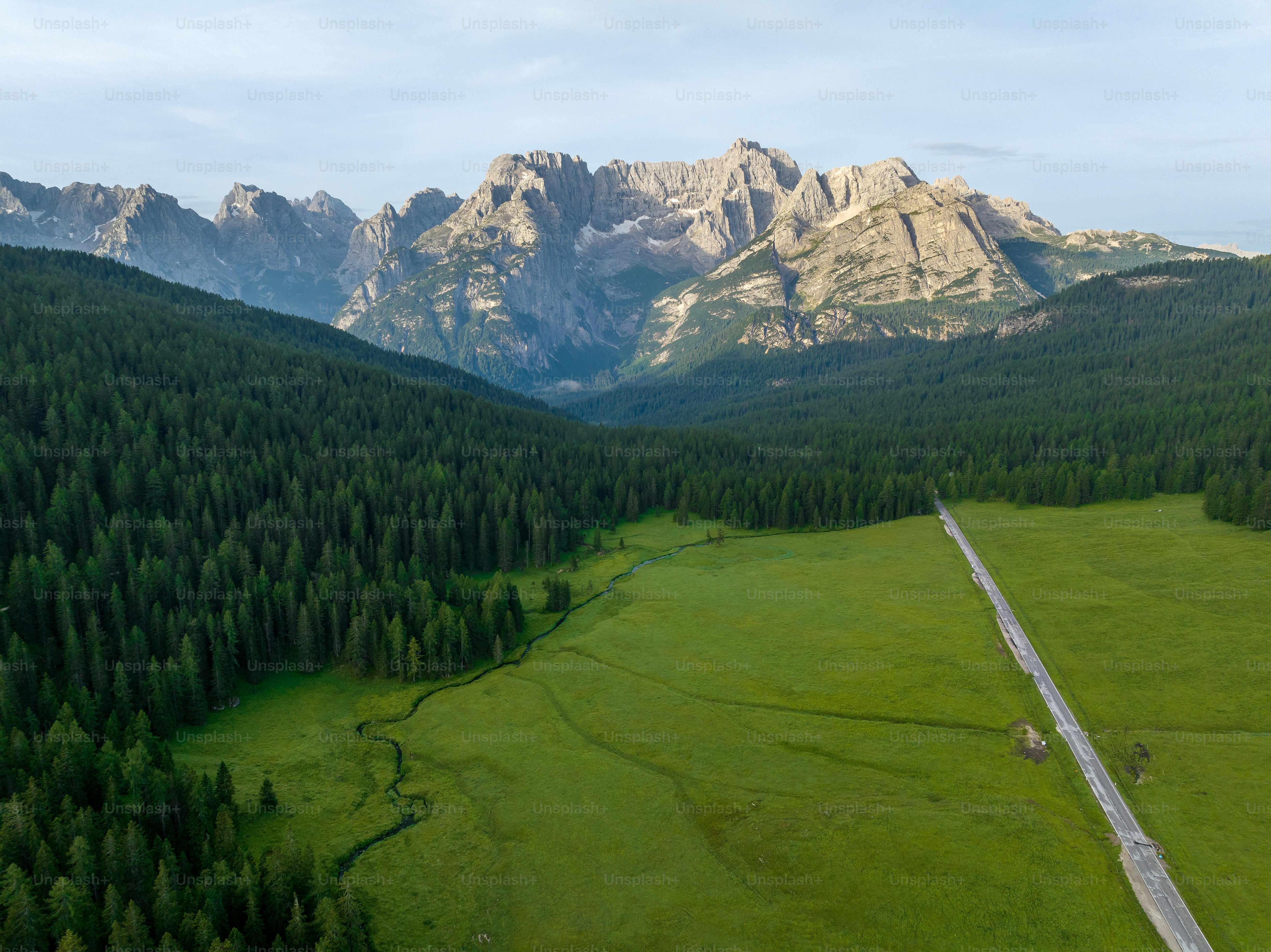 An aerial view of a mountain valley with a road running through it ...