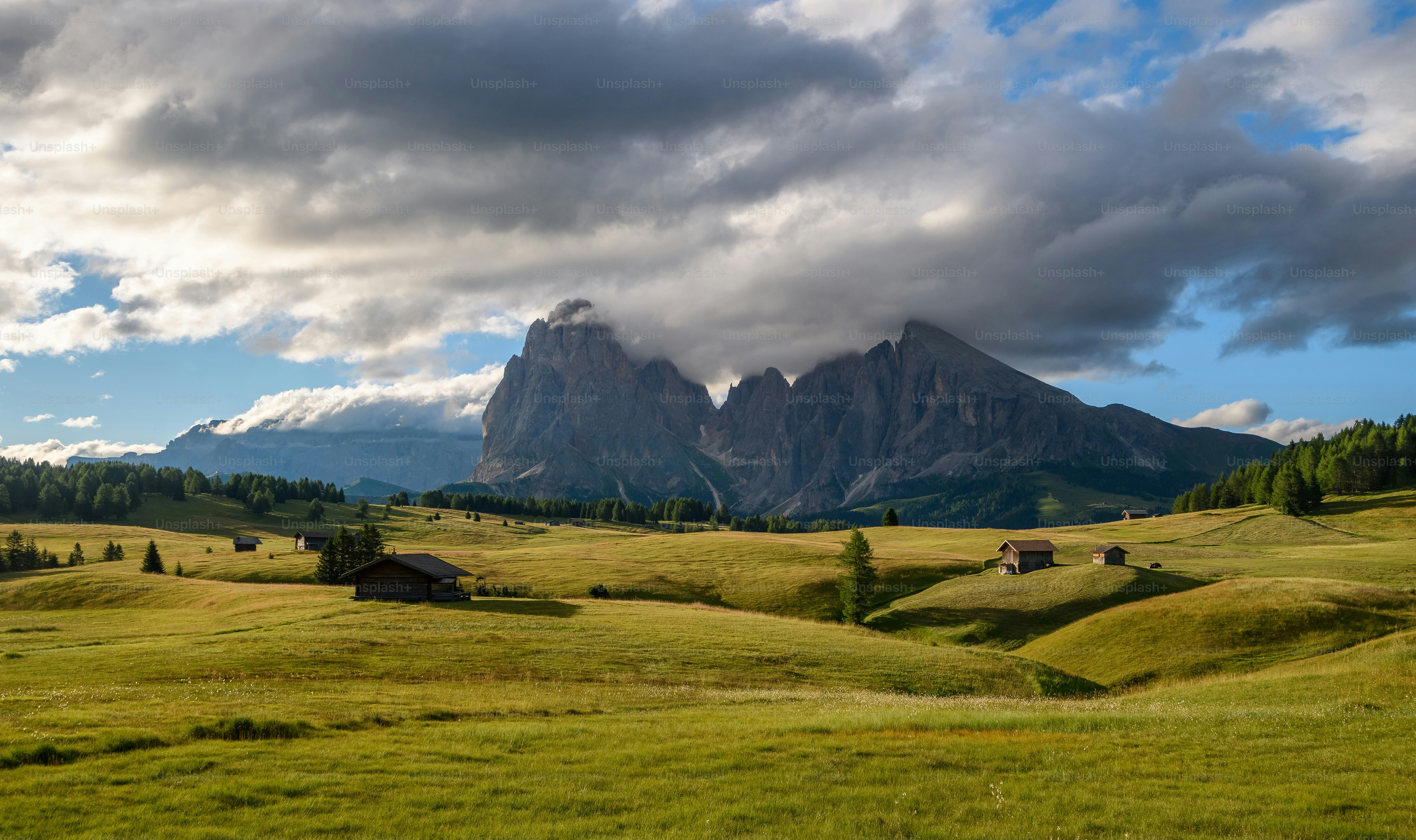 A view of a valley with mountains in the background photo – Italy Image ...
