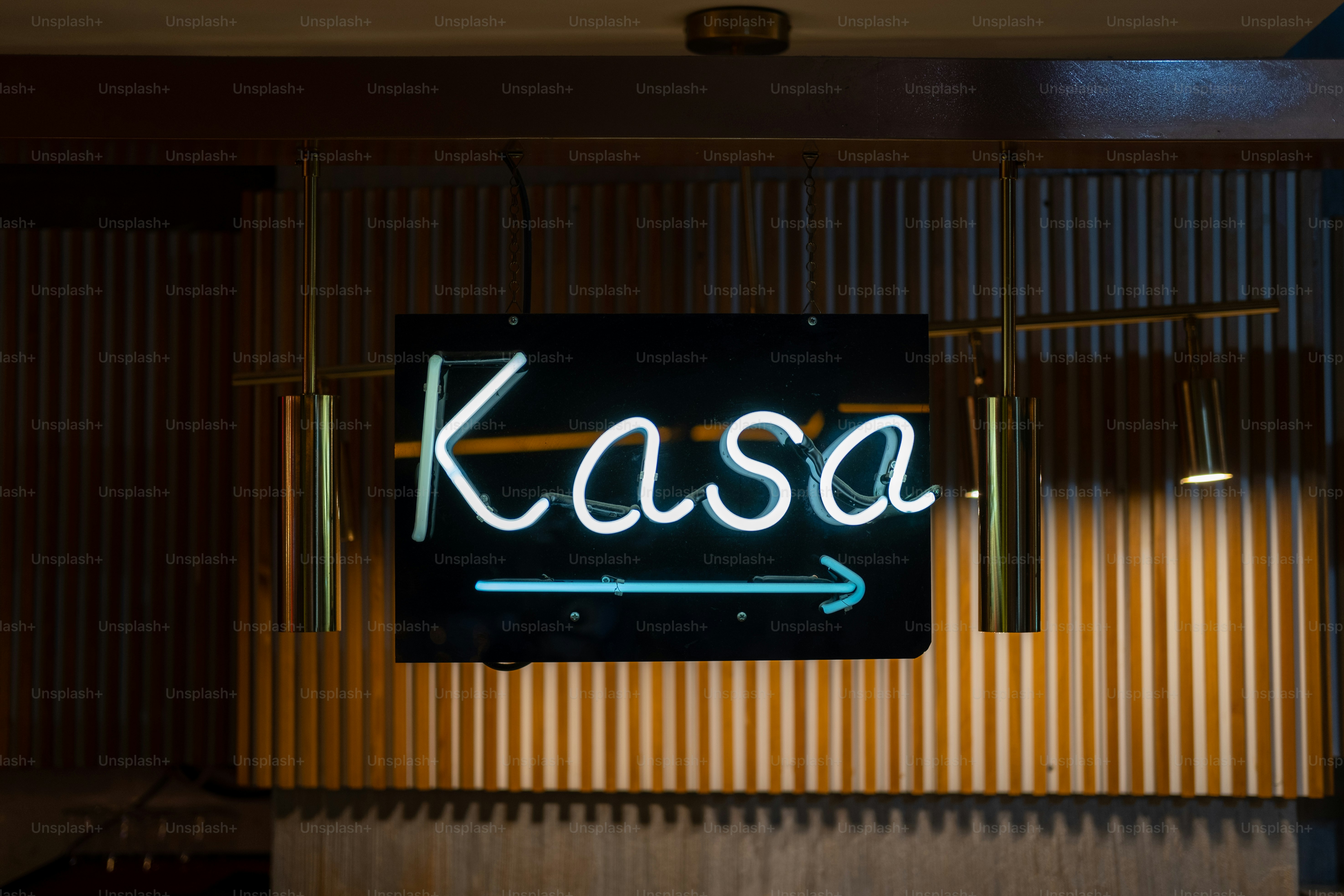 A neon sign hanging from the side of a wall photo – Sign board Image on ...