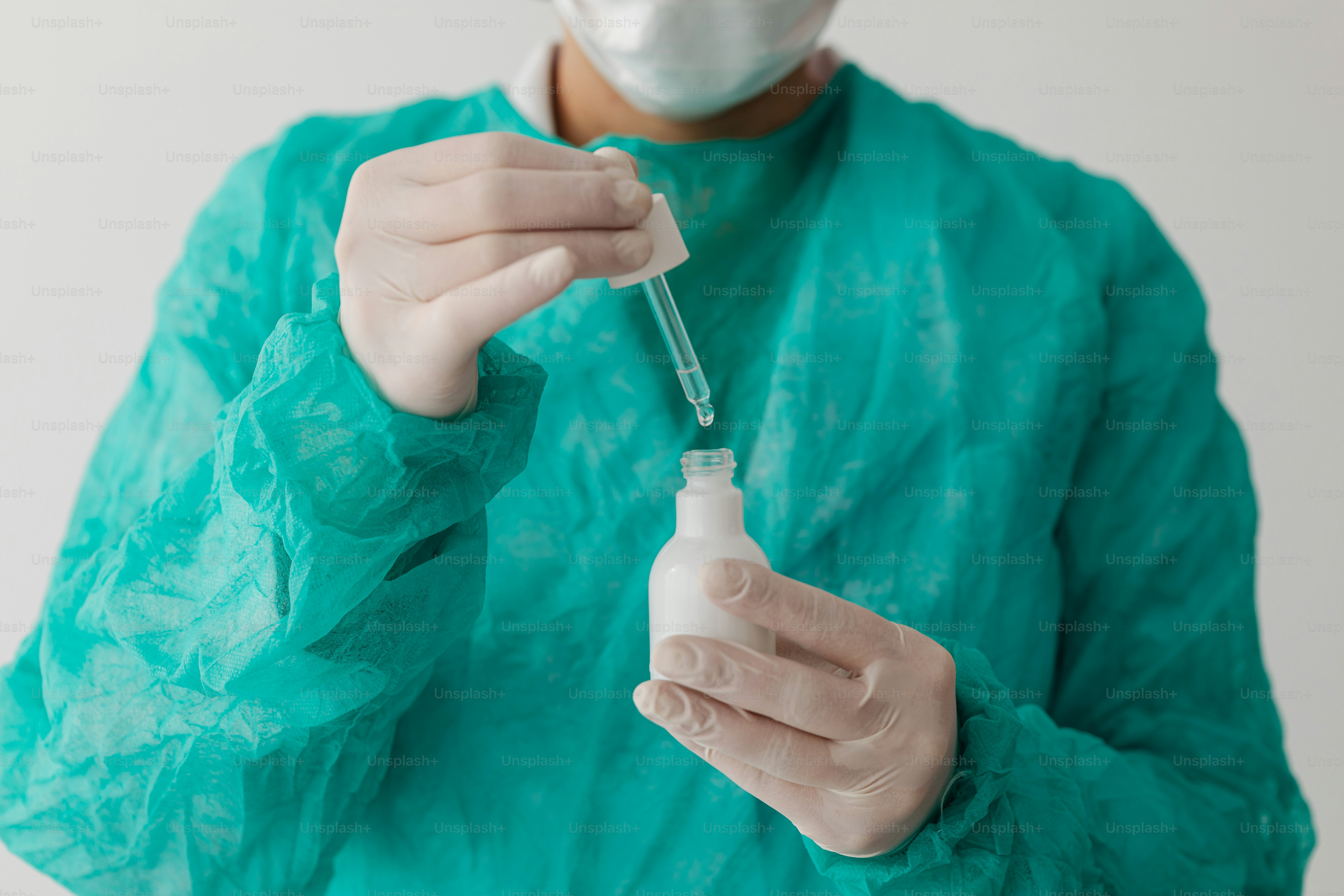 A person in a green scrub suit holding a pipe photo – Technology Image ...