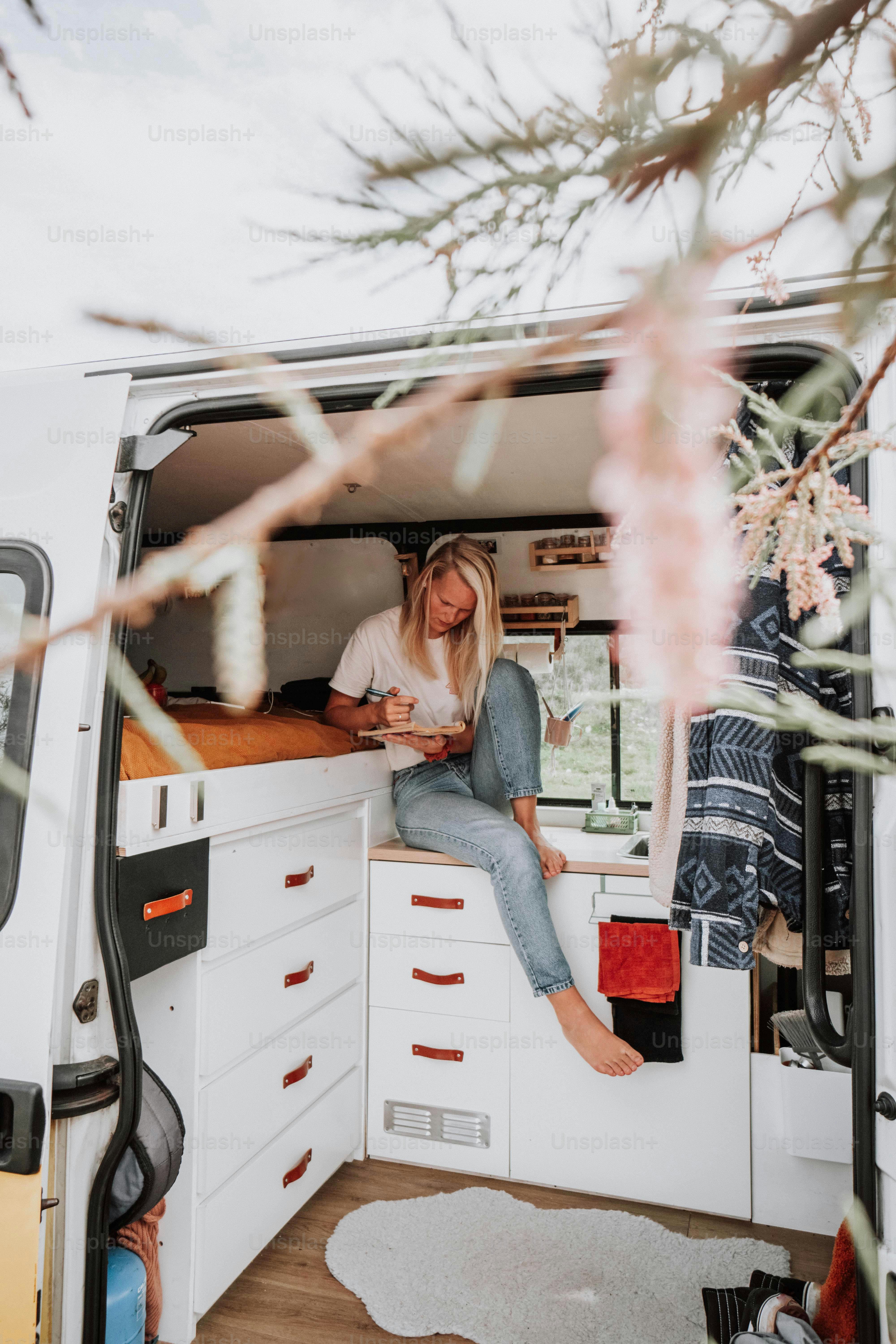 A woman sitting in the back of a van photo – Vacation Image on Unsplash