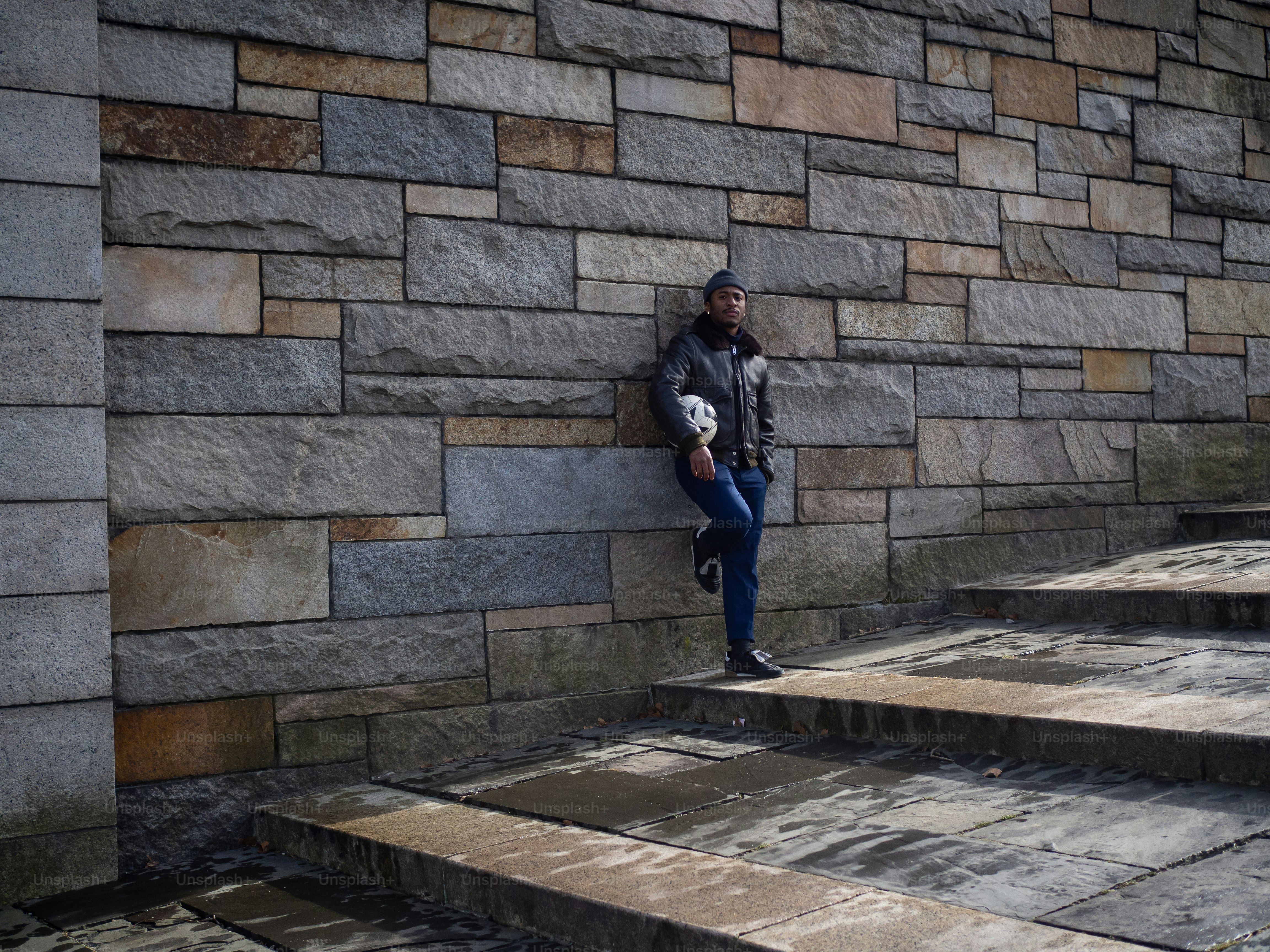 A person leaning against a stone wall photo – Wall Image on Unsplash