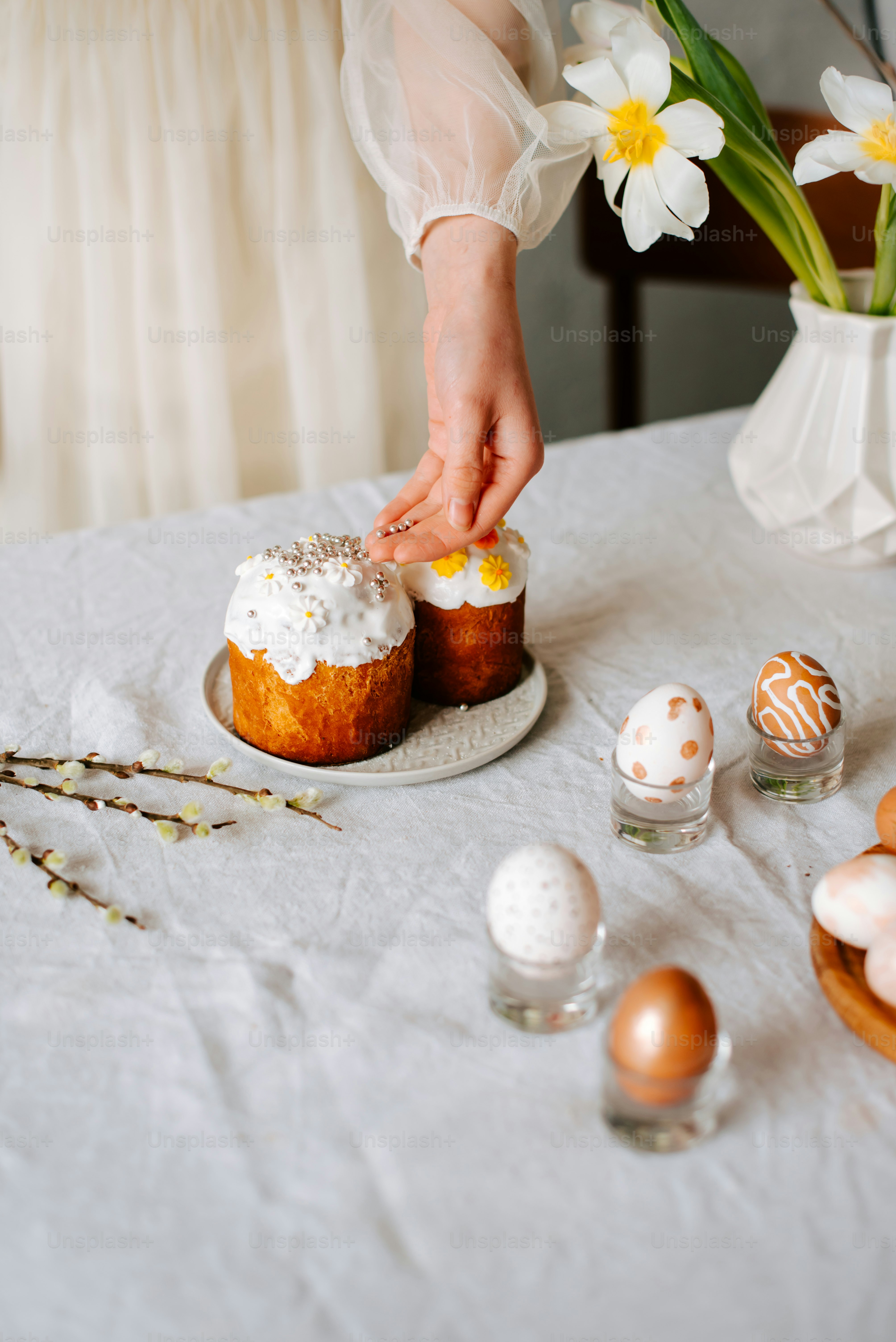 A person decorating a cake on a table photo – Woman Image on Unsplash