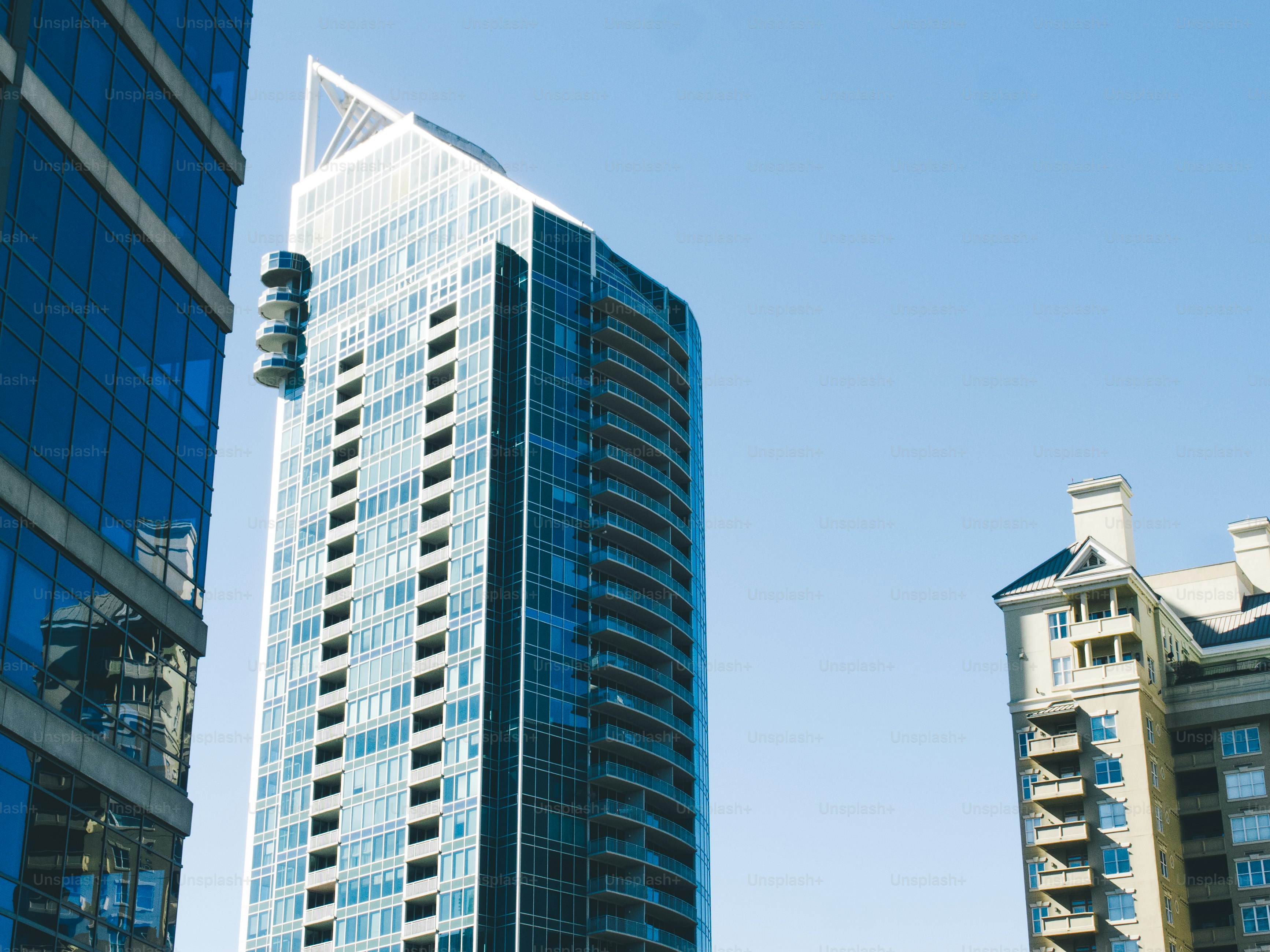 A very tall building towering over a city photo – Sky city Image on ...