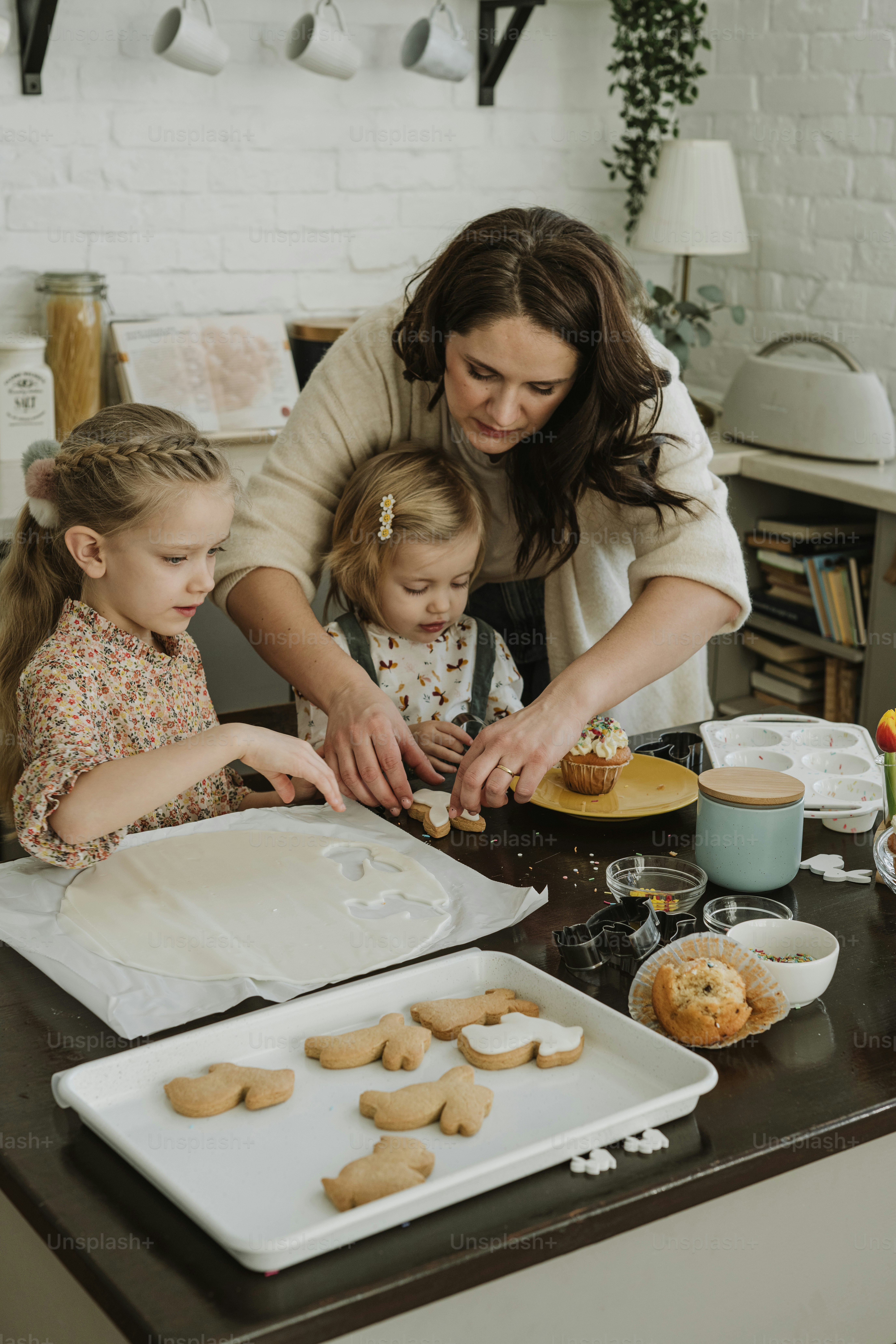 A woman and two young girls making cookies photo – Family Image on Unsplash