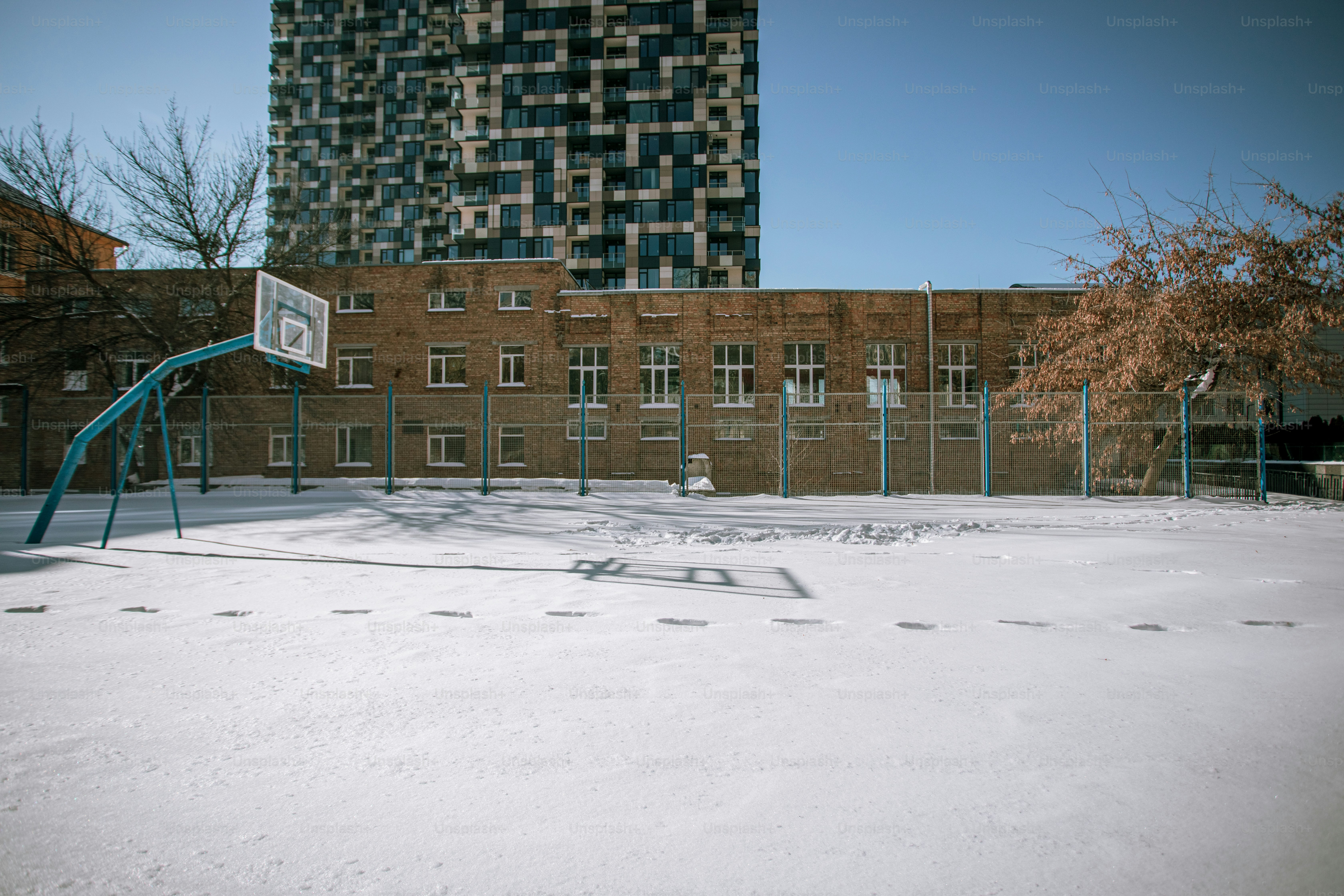 A basketball court with a basketball hoop in the snow photo ...