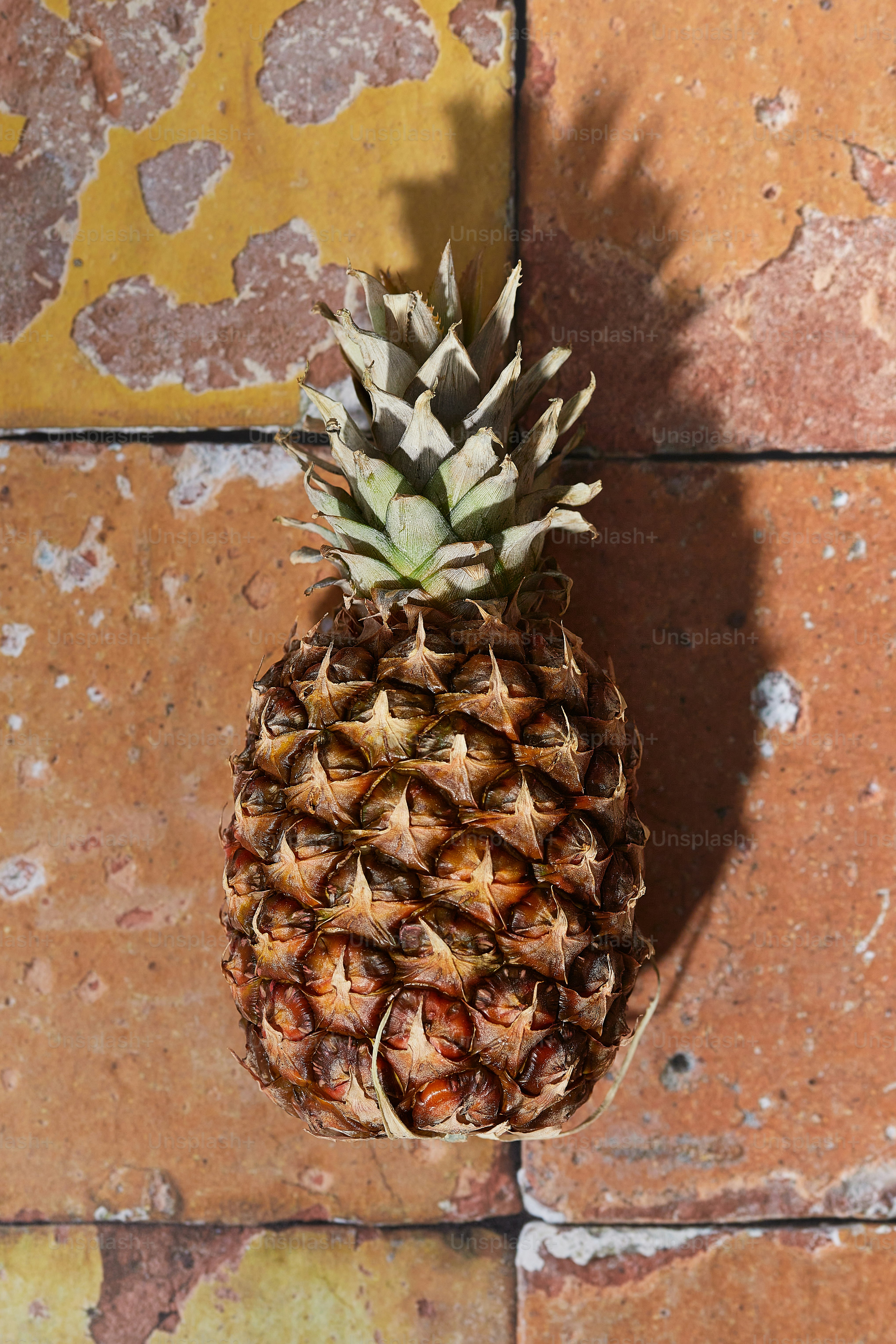 A pineapple sitting on top of a brick floor photo – Hawaiian Image on Unsplash