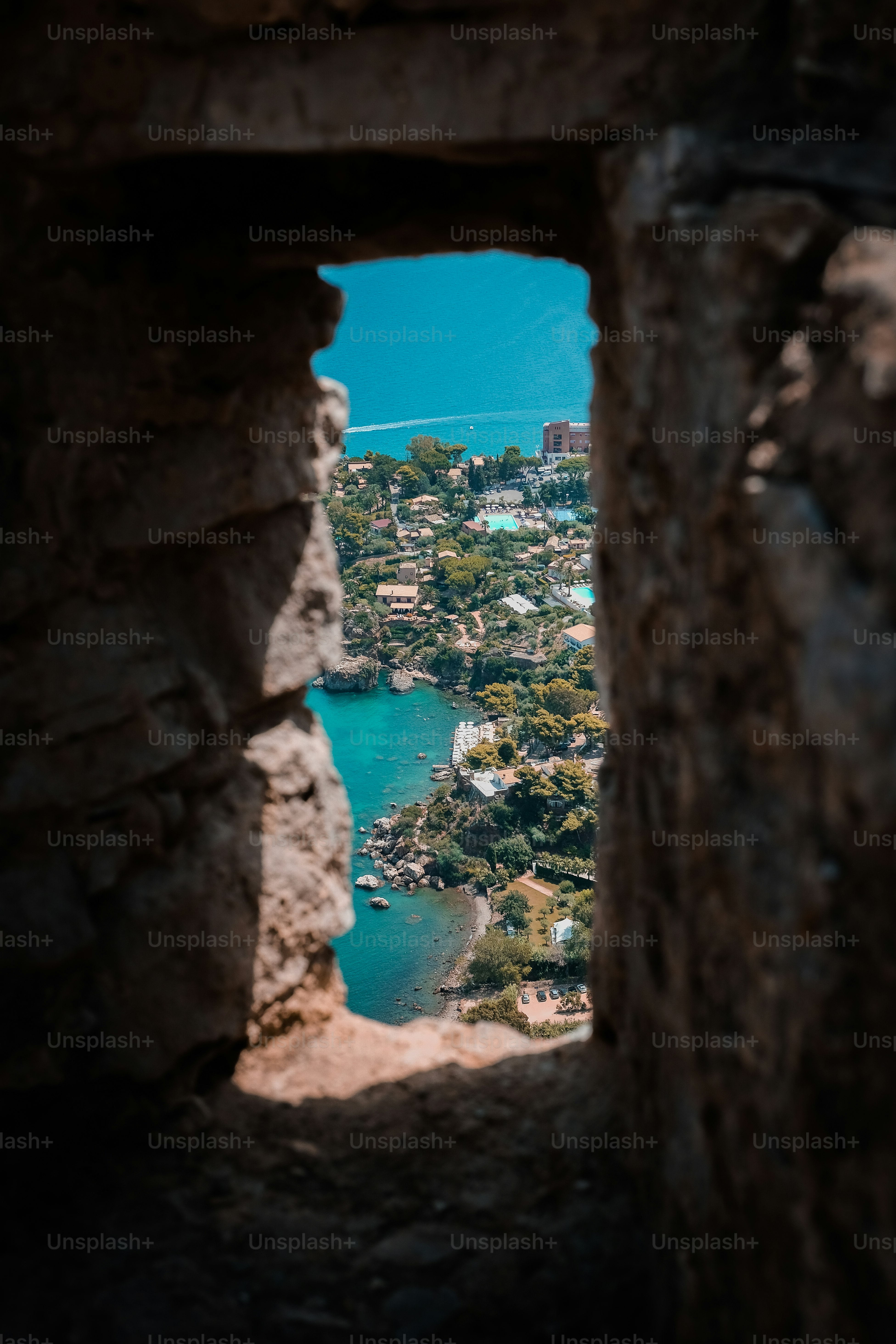 A view of a lake through a hole in a stone wall photo – Italy Image on ...