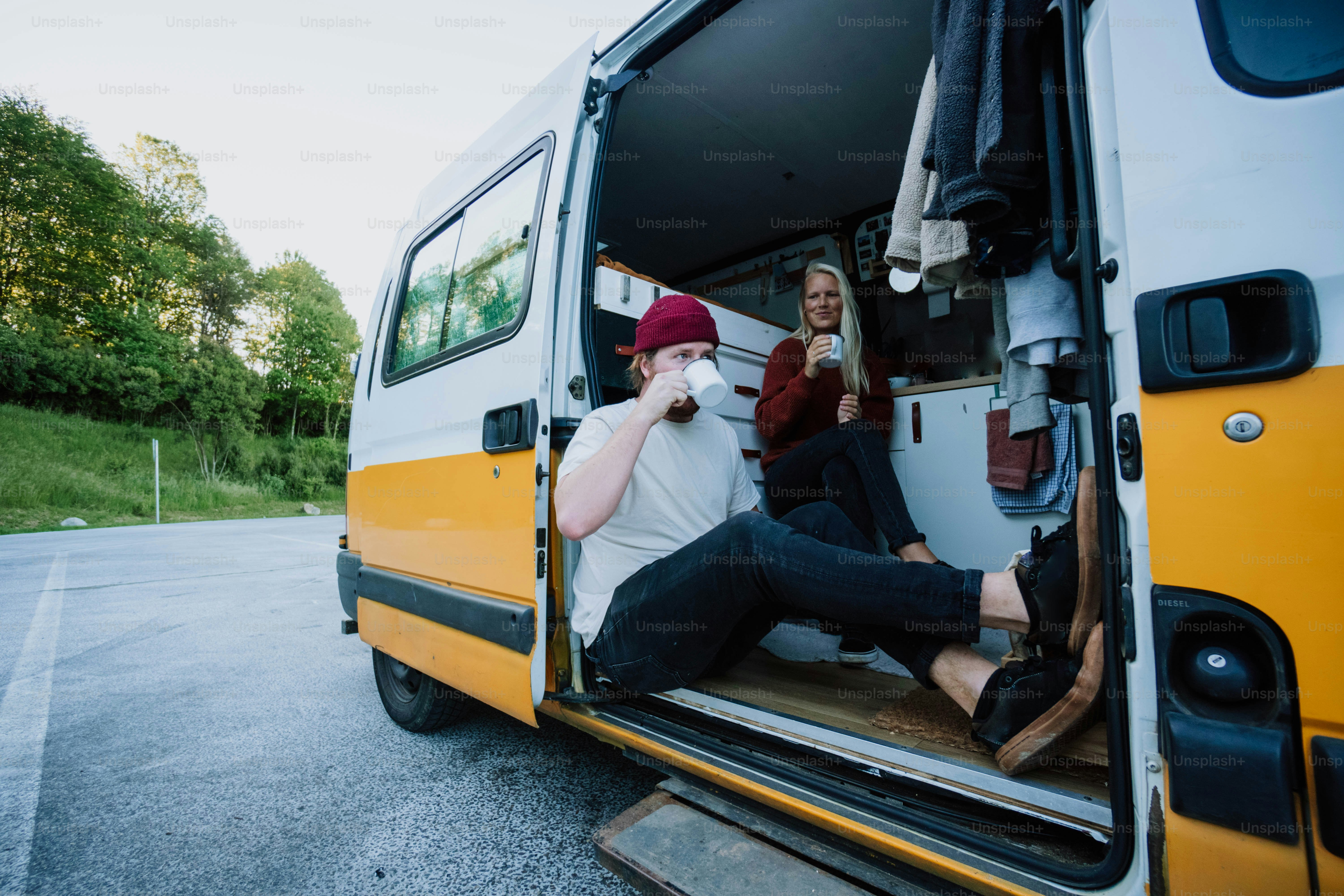 A couple of people sitting in the back of a van photo – Minivan Image ...