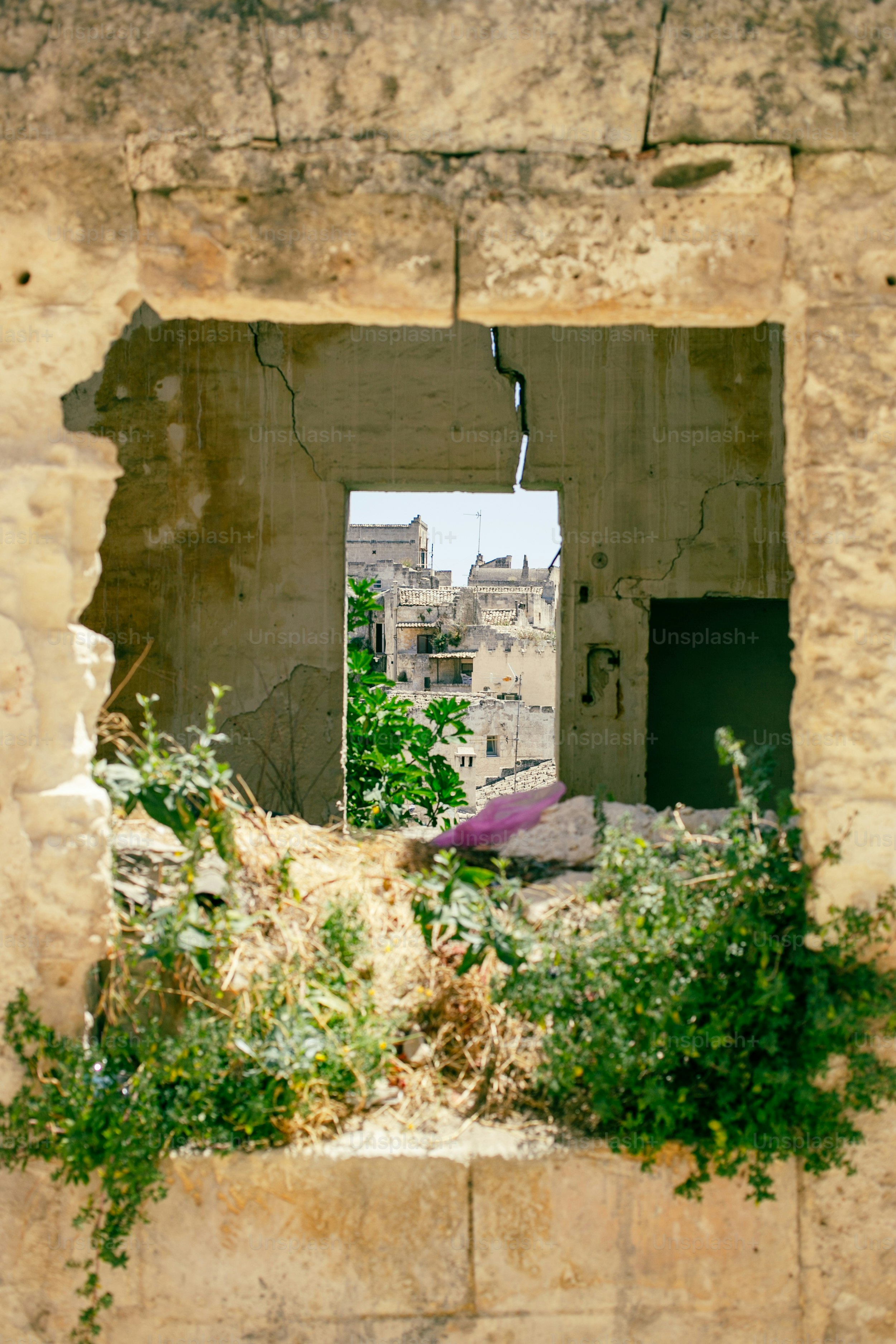A window in a wall with a view of a city photo – Italy Image on Unsplash