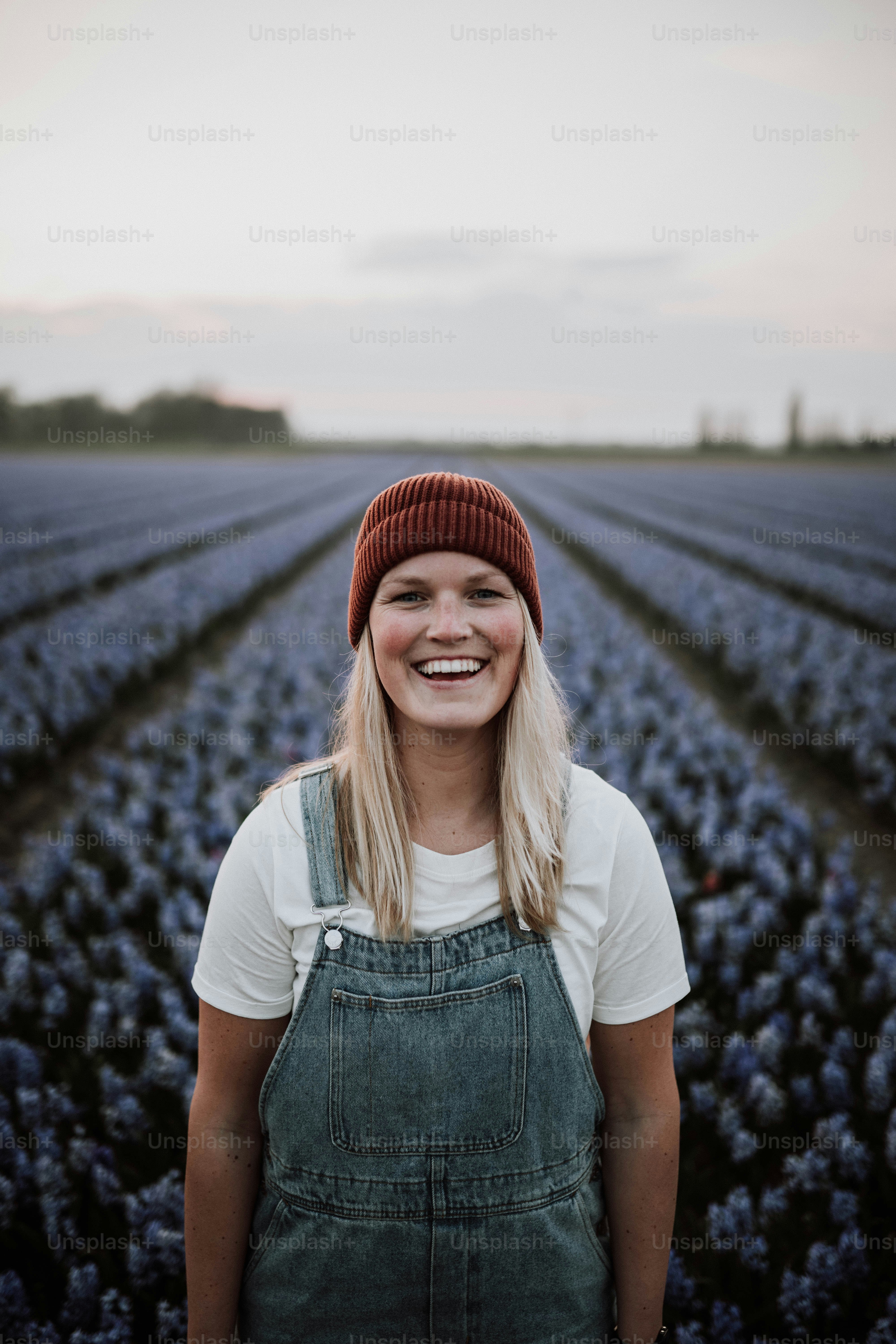 A woman standing in front of a field of blue flowers photo – Spring ...