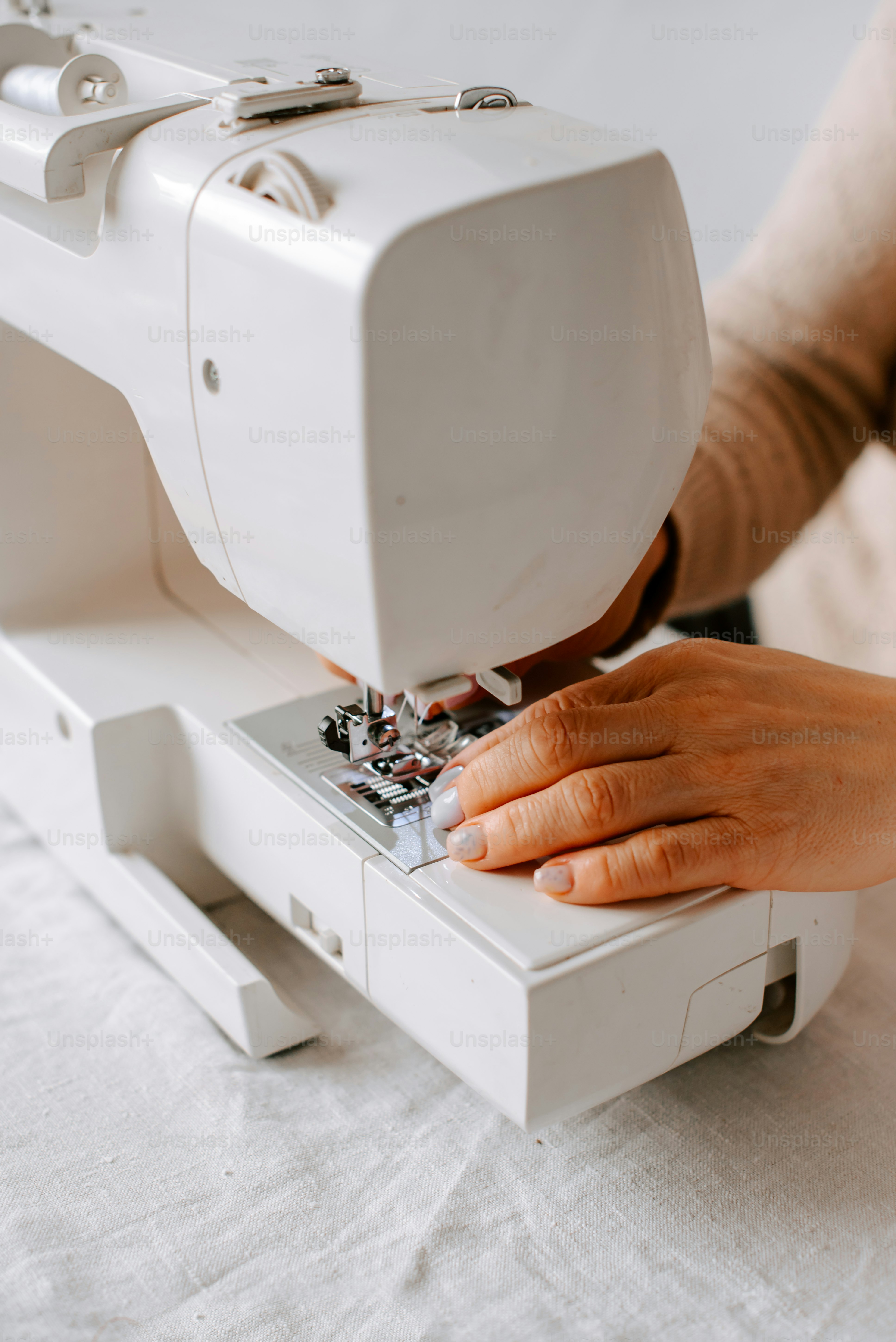 A person using a sewing machine to sew a piece of fabric photo – Tailor ...