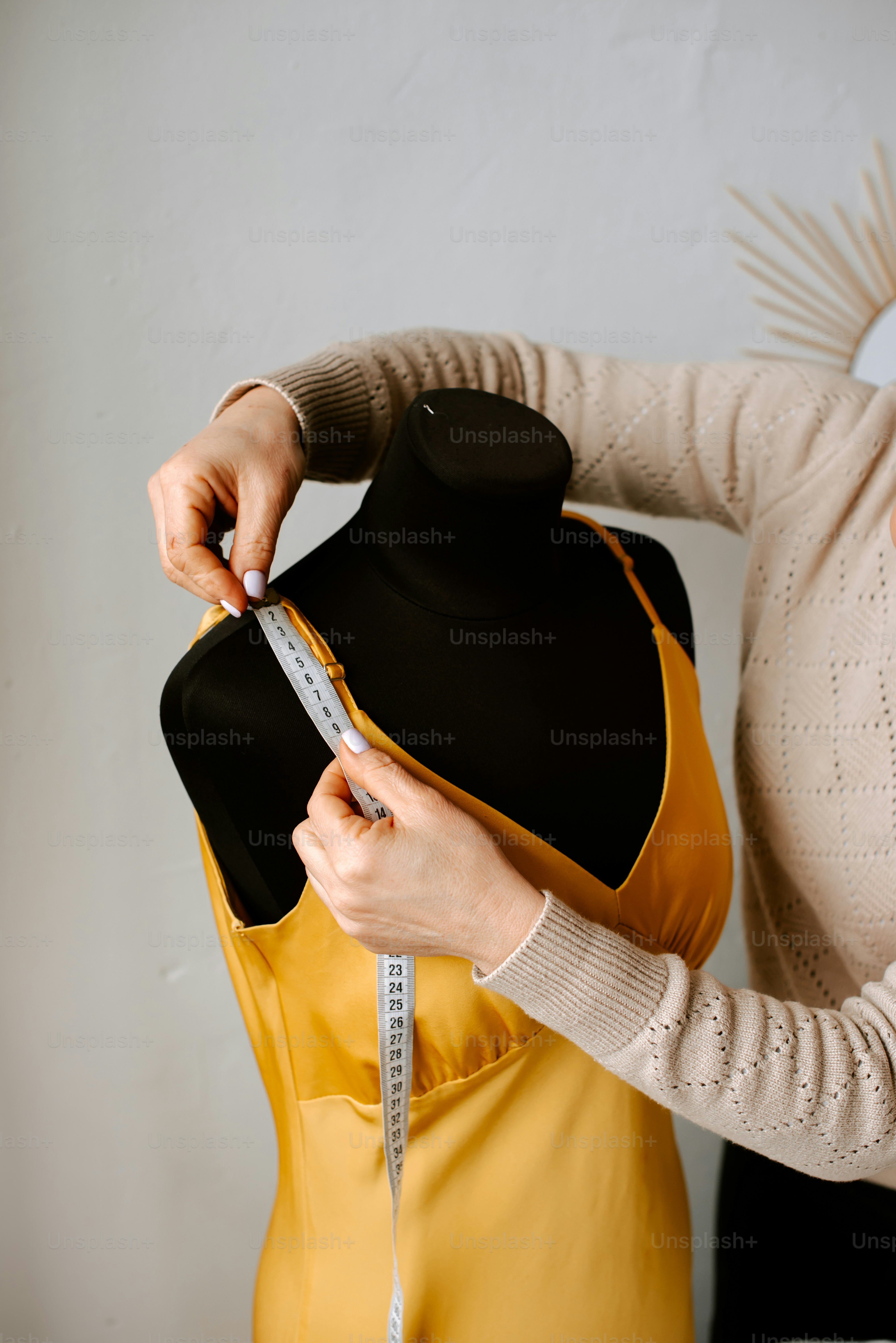 A woman measuring a dress on a mannequin photo – Tape measure Image on ...