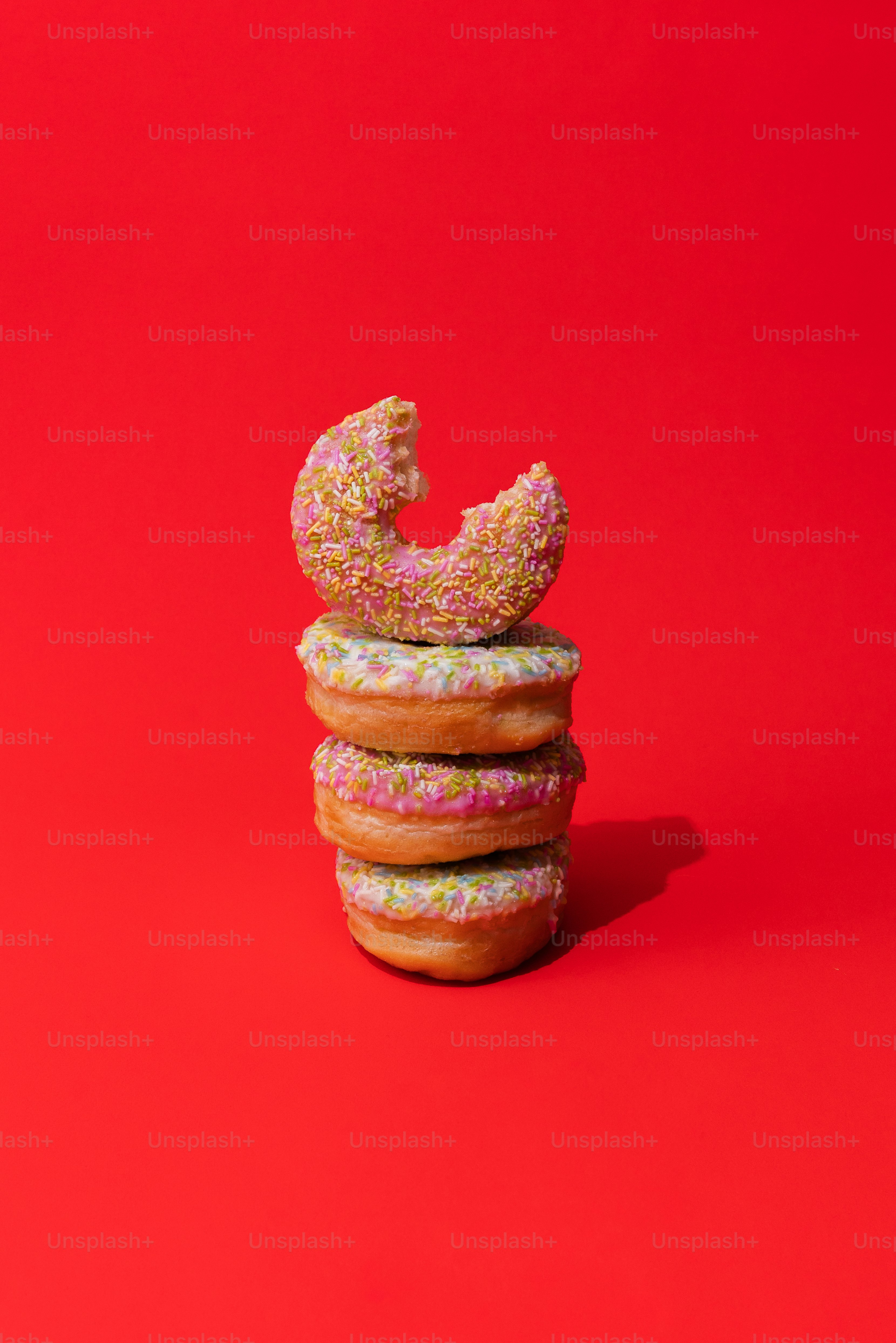 A stack of doughnuts sitting on top of each other photo – Doughnuts ...