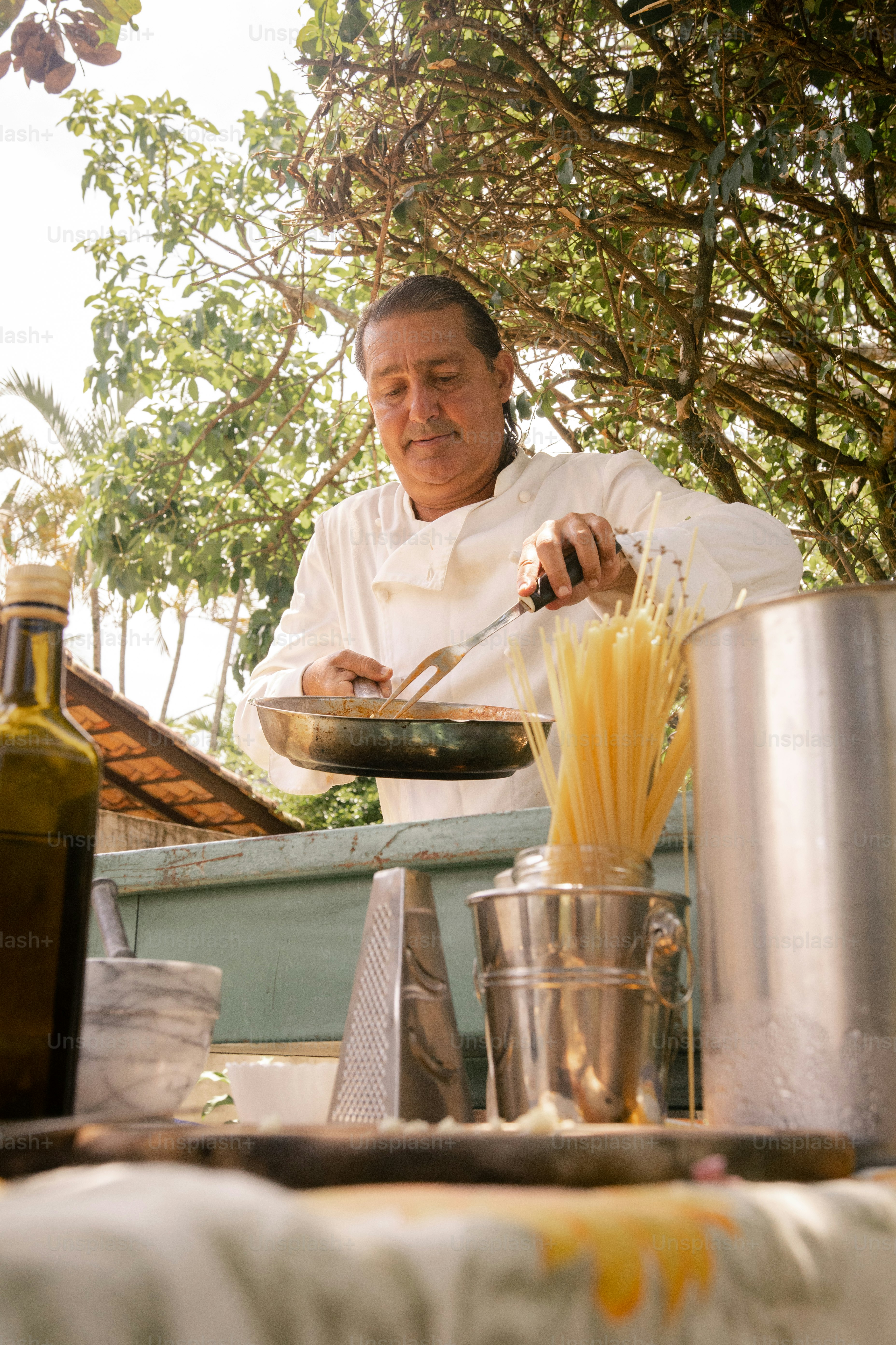 A man cooking pasta in a pan on a table photo – Garden Image on Unsplash