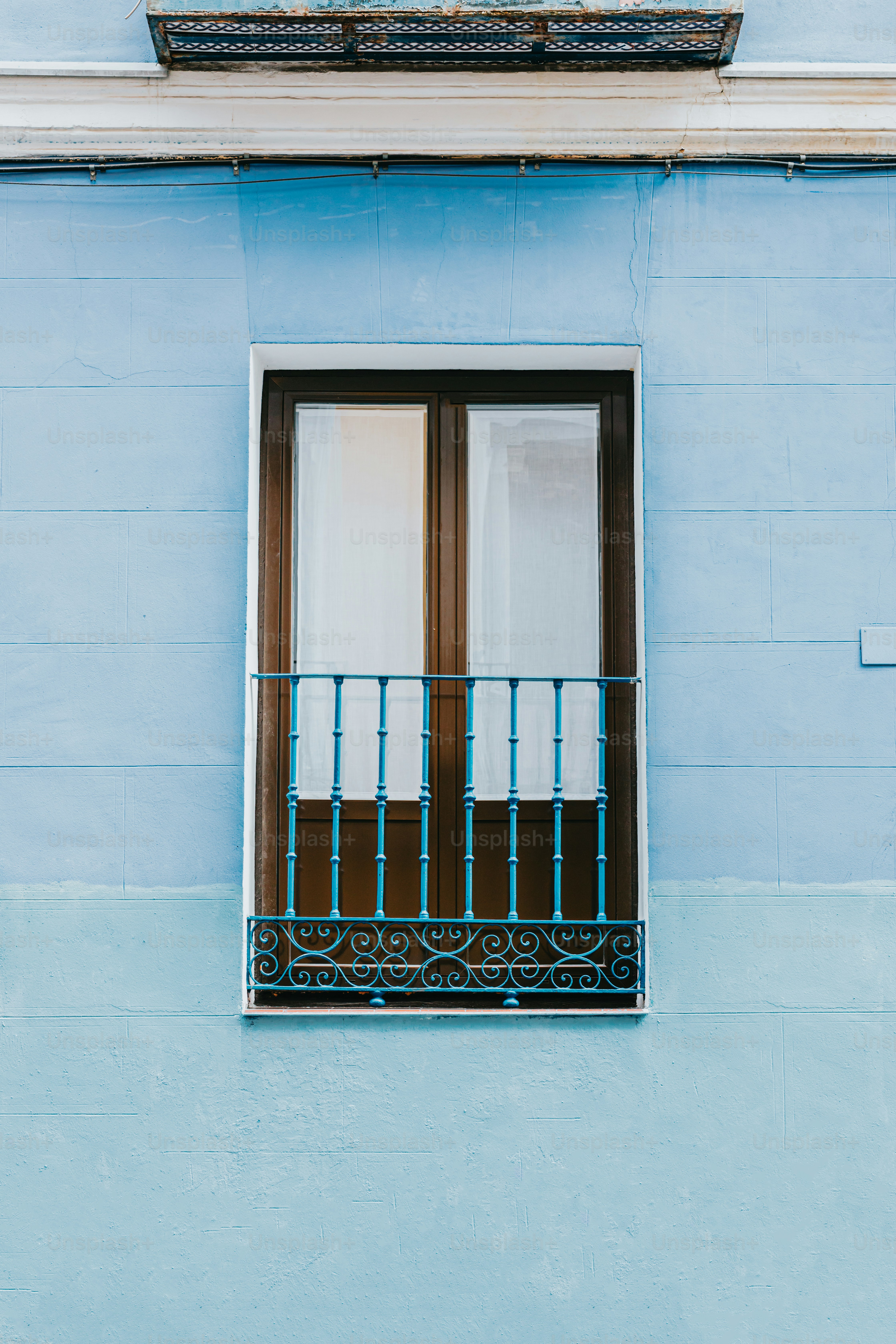 Un bâtiment bleu avec une fenêtre et un balcon photo – Bâtiment bleu ...