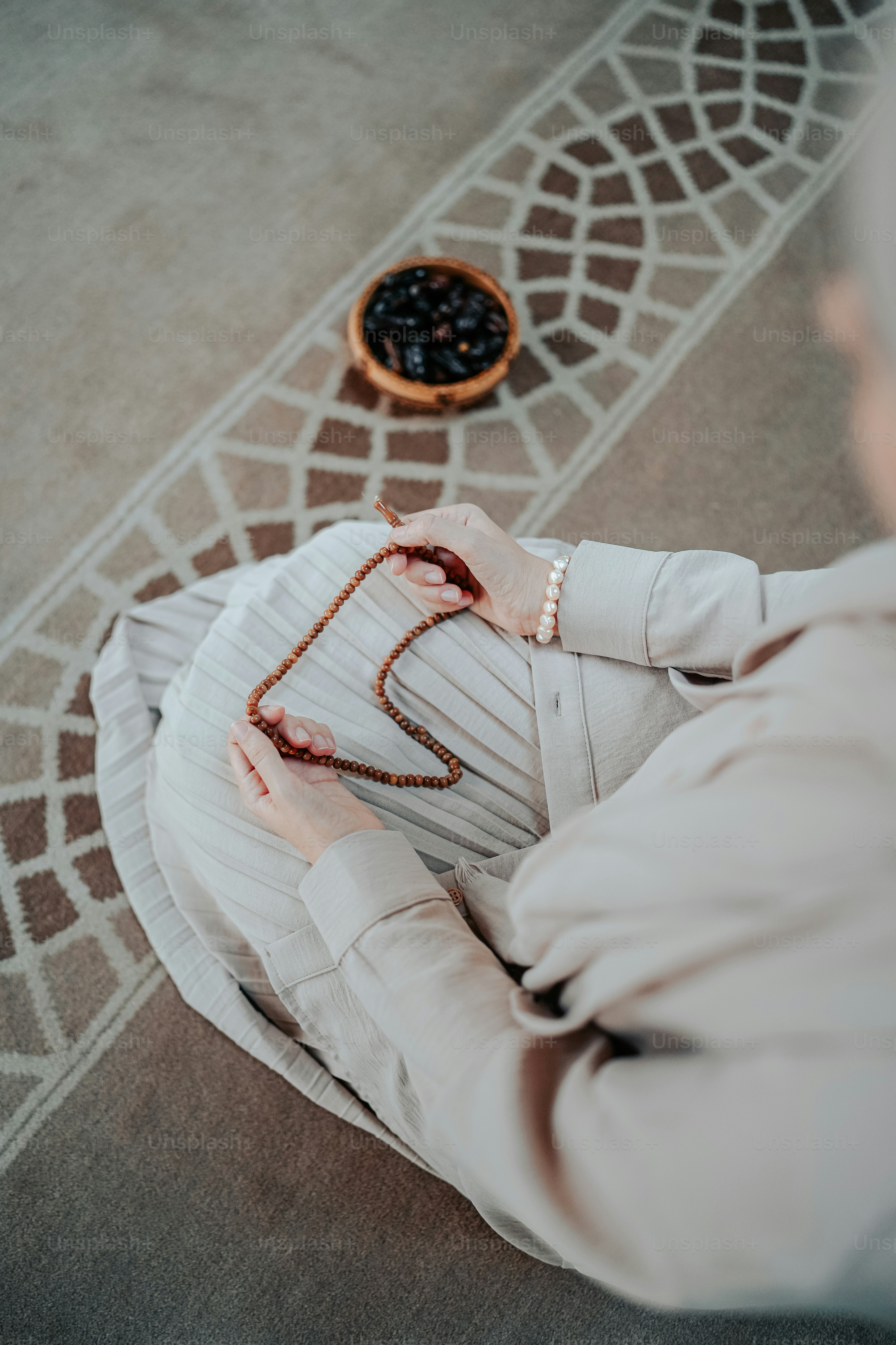 A person sitting on the ground holding a plate with a cake on it photo ...