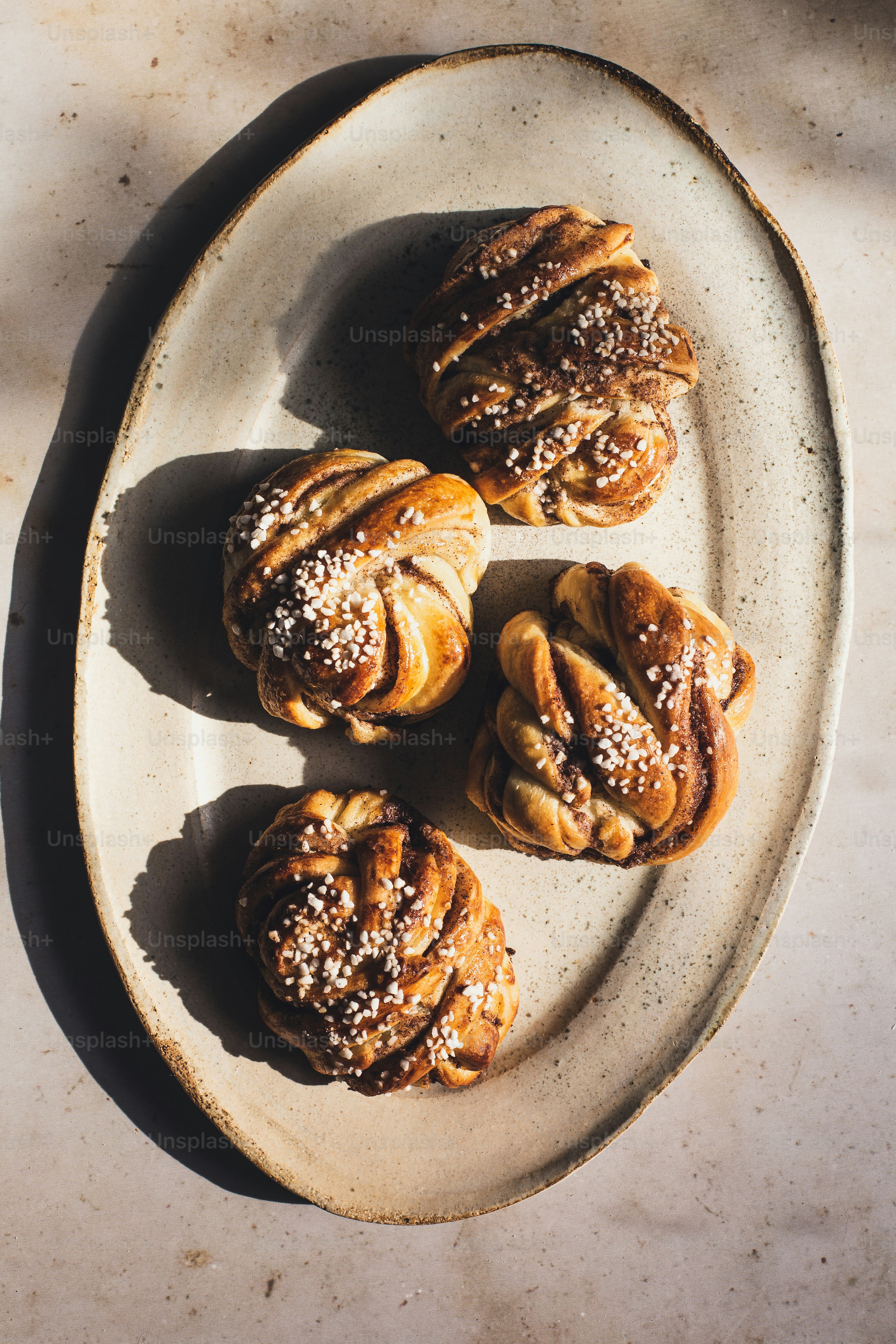 A white plate topped with pastries on top of a table photo – Baked ...