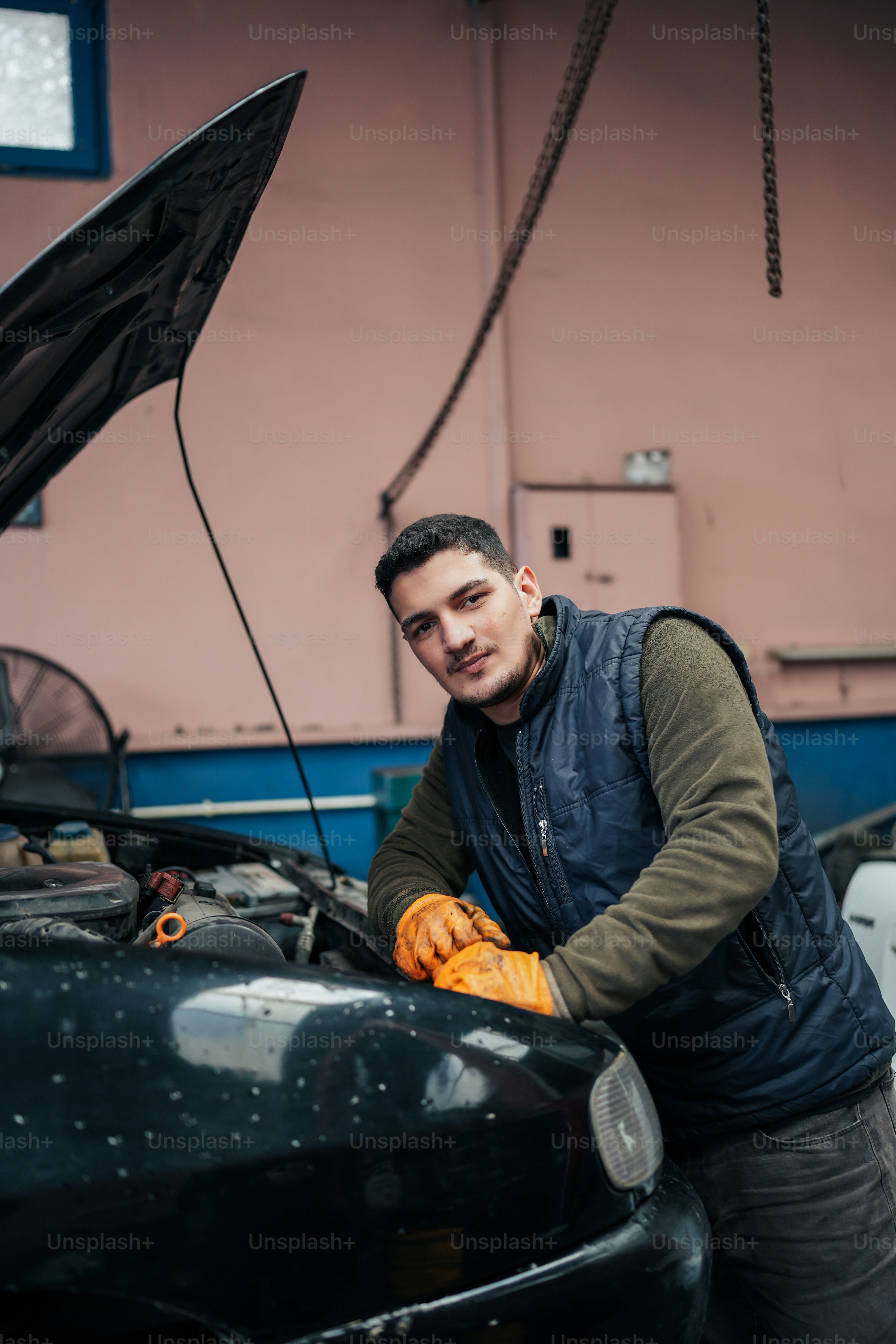 A man working on a car in a garage photo – Automotive Image on Unsplash