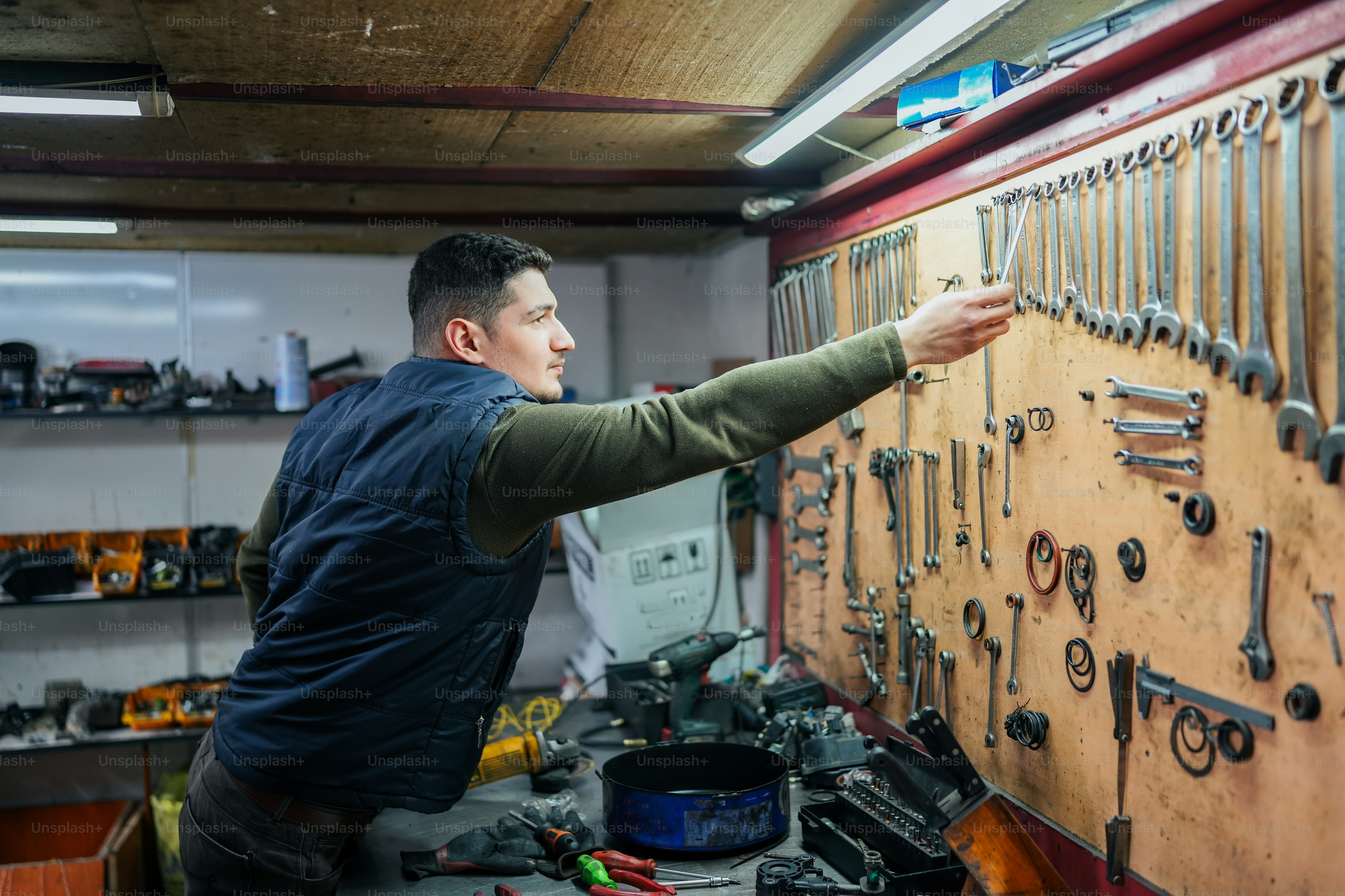 A man working on a wall of tools photo – Car Image on Unsplash