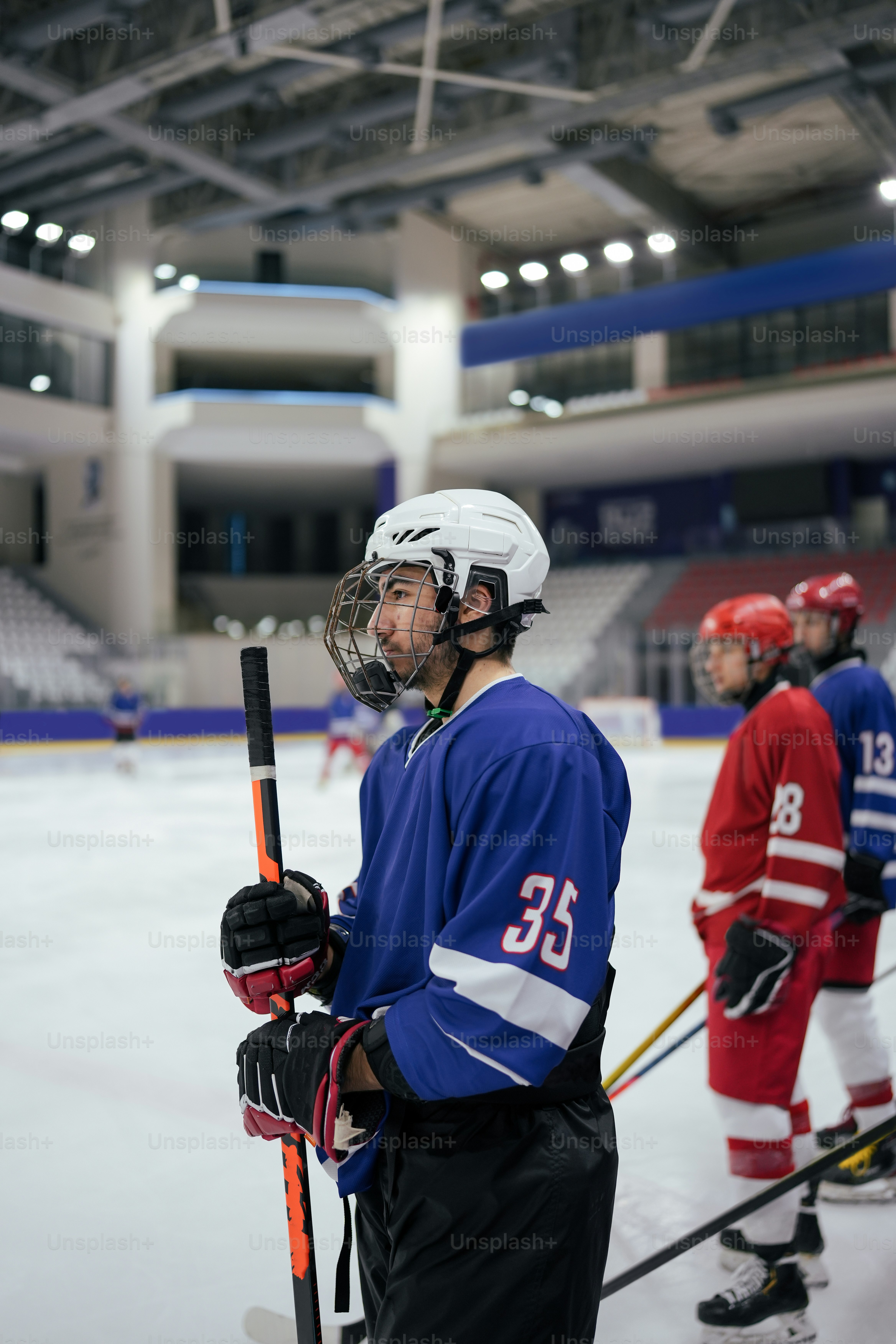 A couple of men standing on top of a ice rink photo – Hockey Image on ...