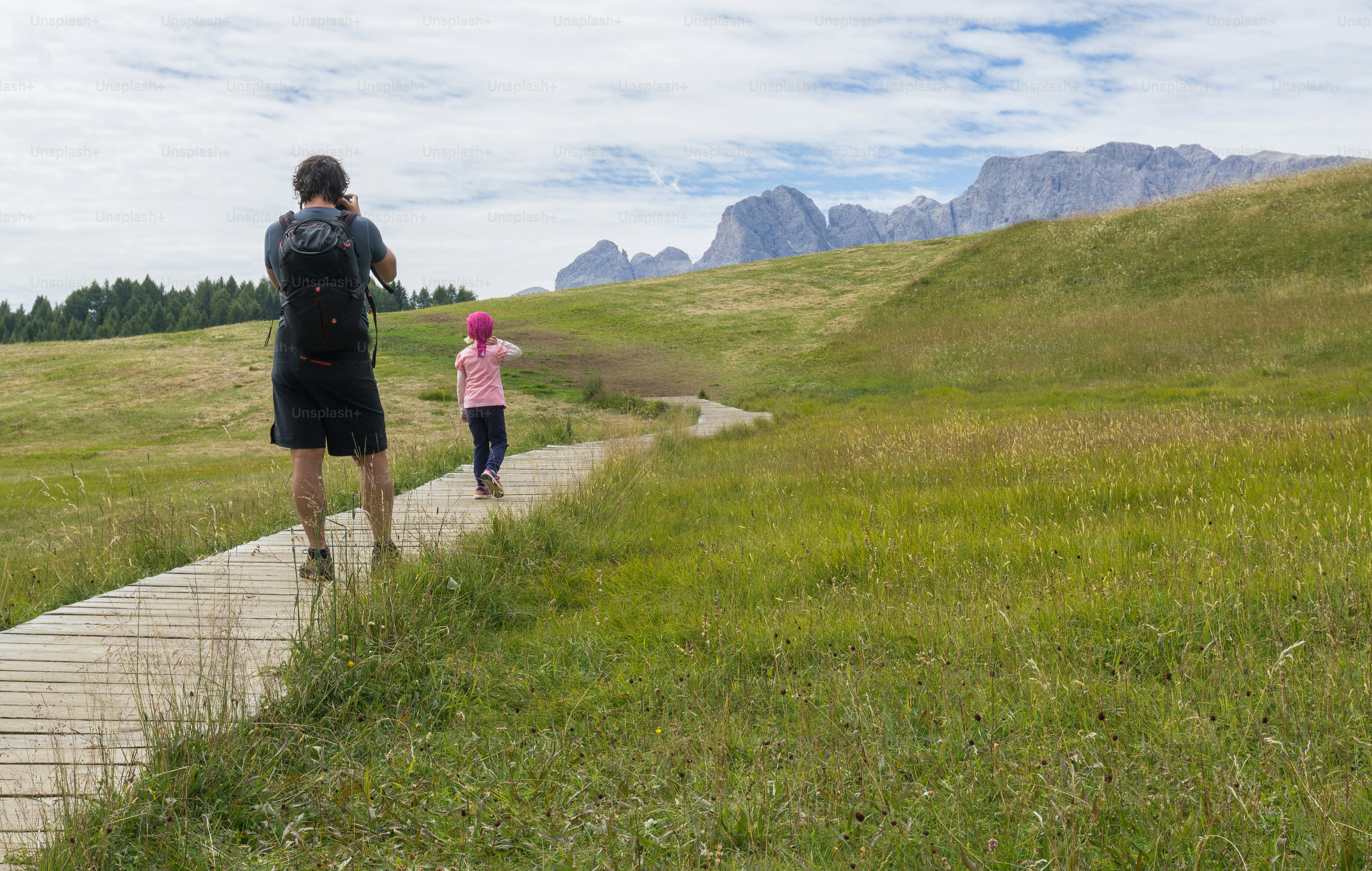 A woman and a child are walking on a path photo – Italy Image on Unsplash