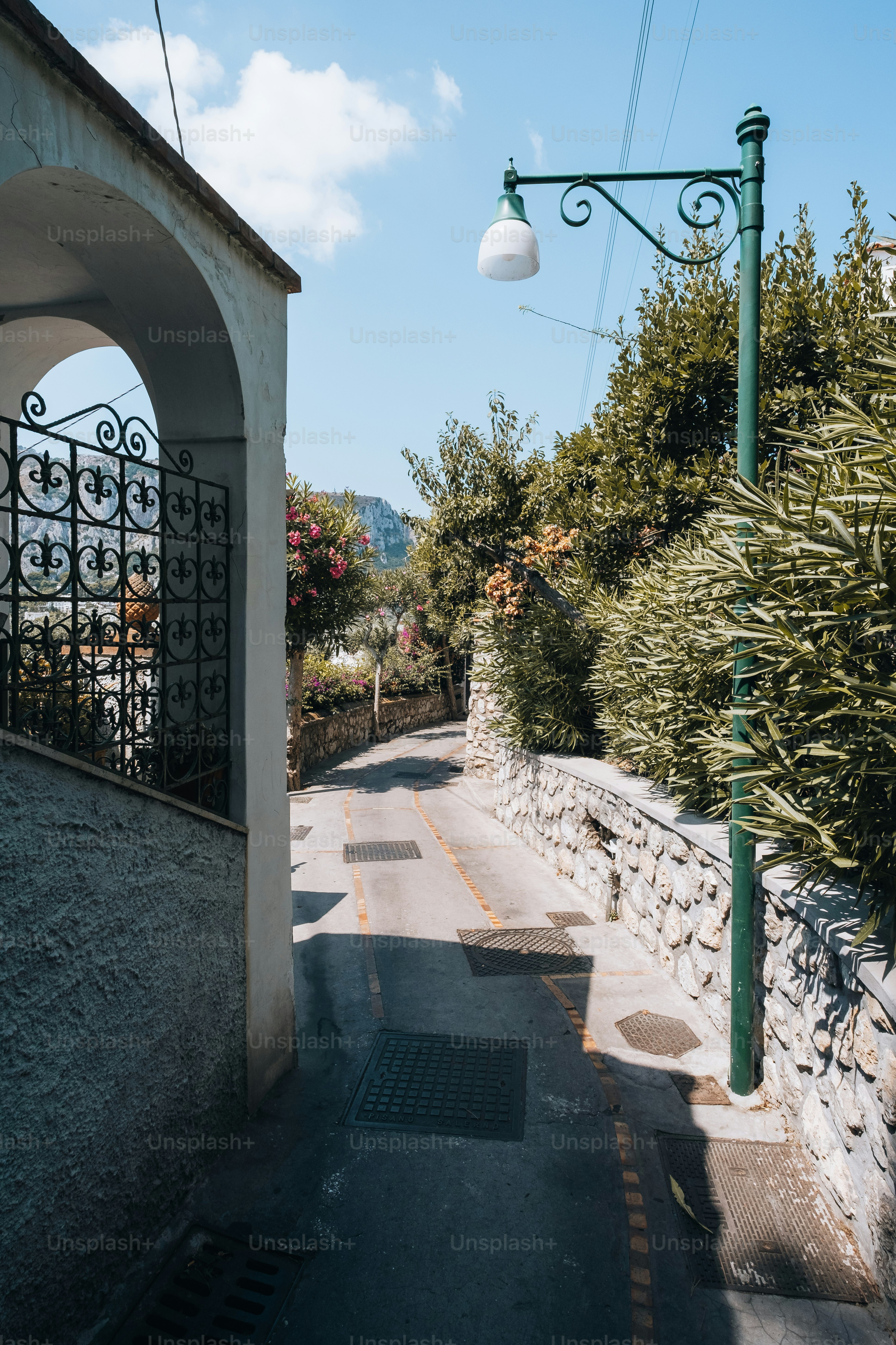 Une rue avec un lampadaire et un mur de pierre photo – Italie Photo sur ...