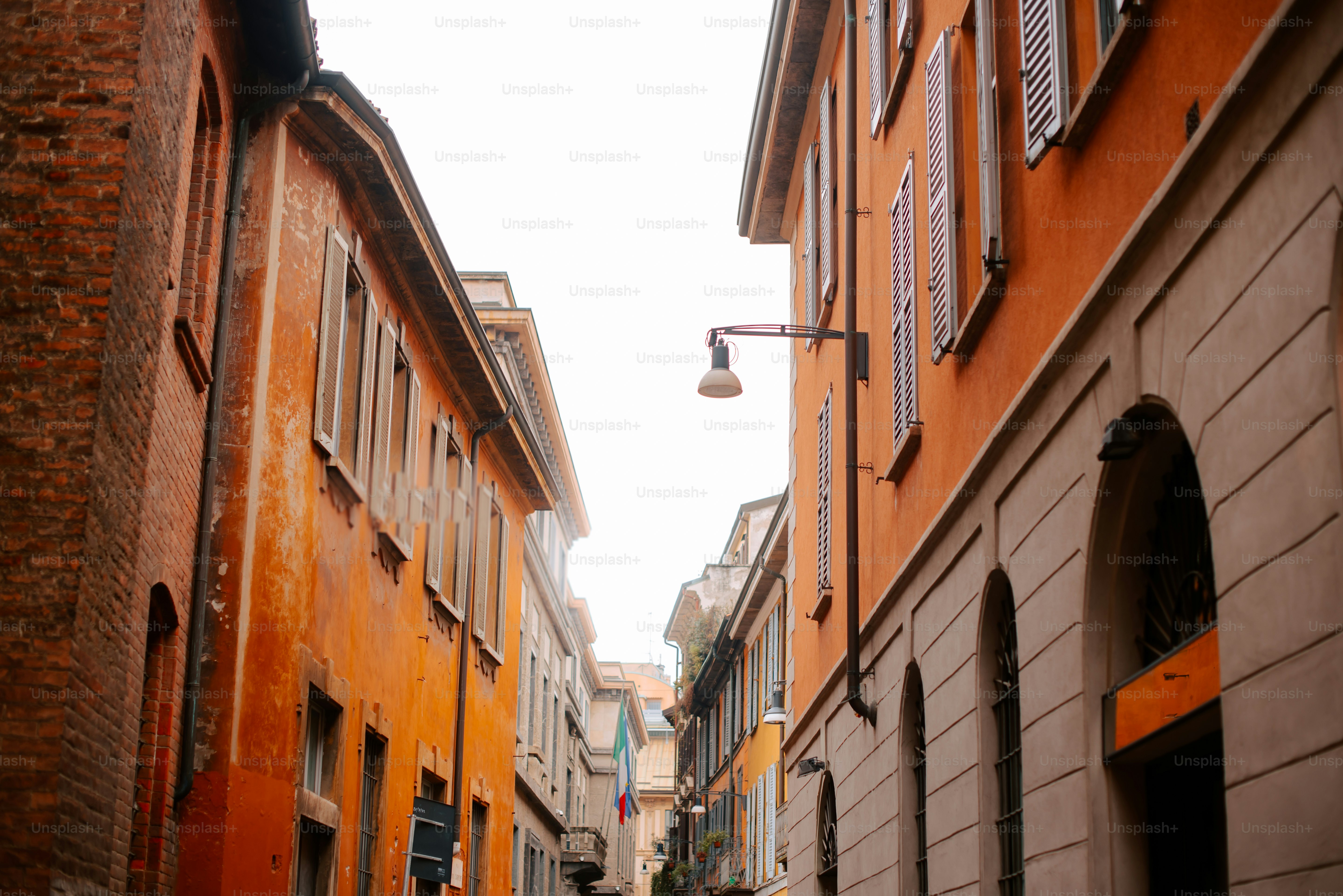 A narrow alleyway between two buildings in a city photo – Milan Image ...