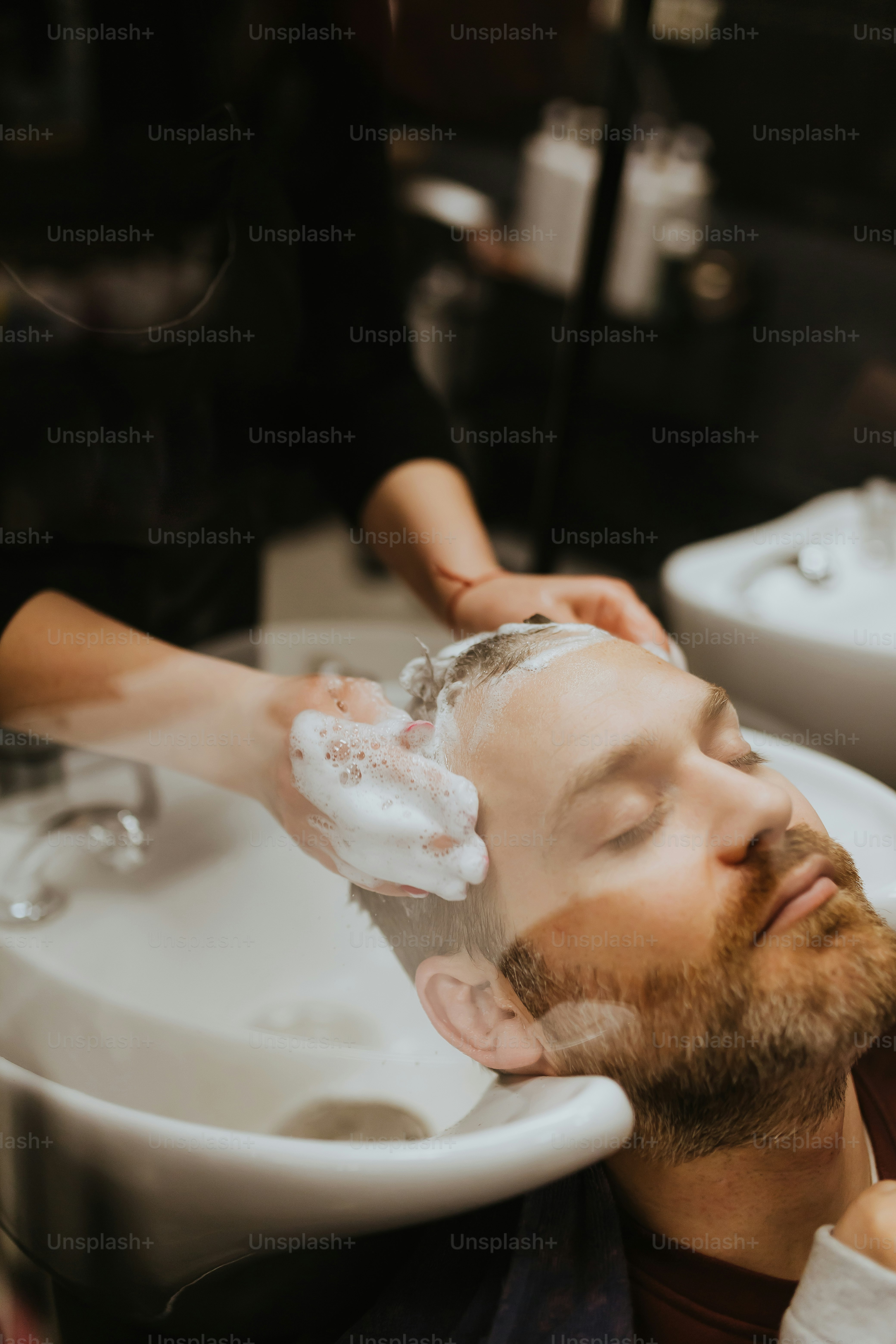 A man getting his hair washed in a sink photo – Mens haircut Image on ...