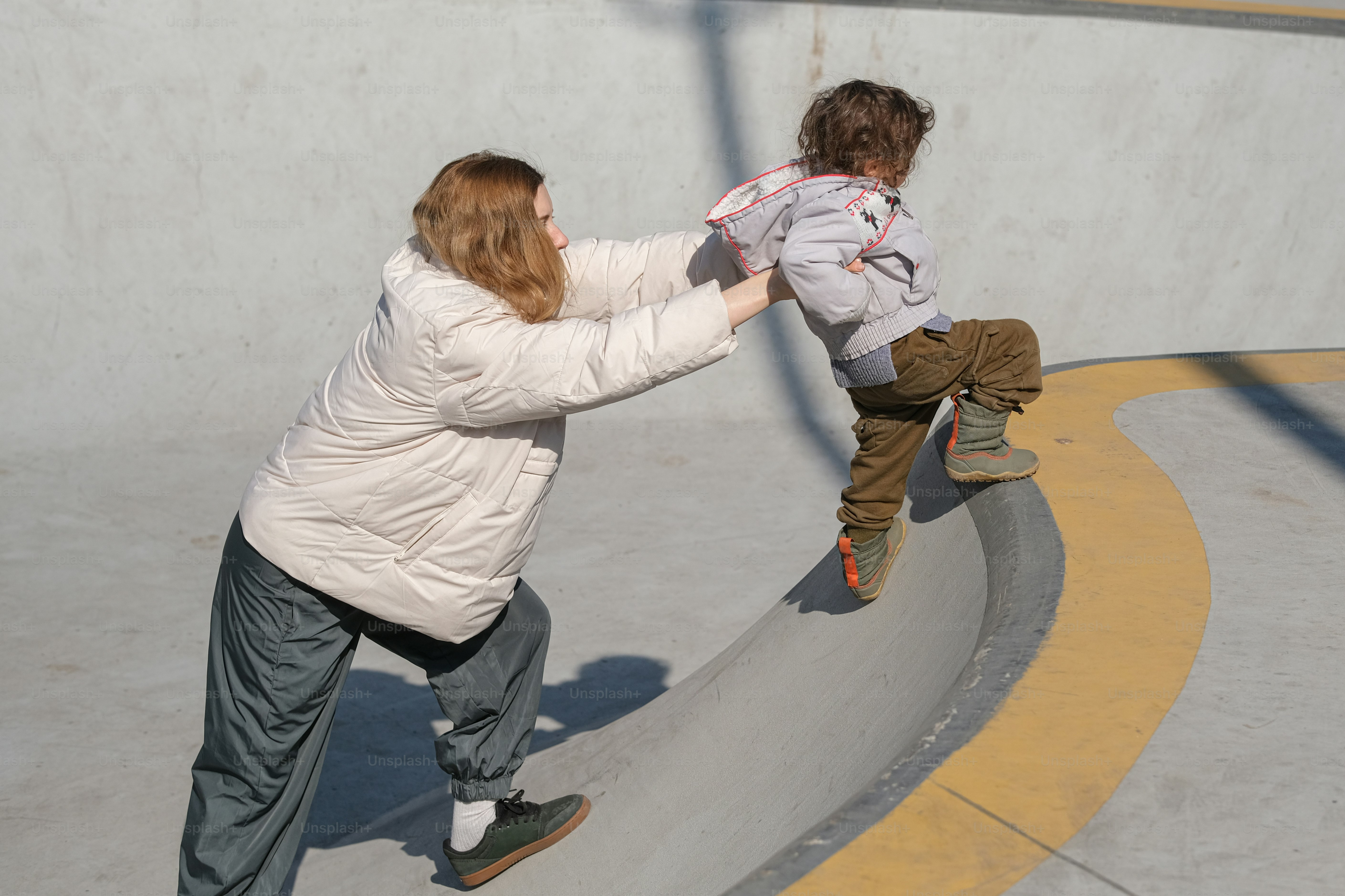 A woman and a child playing on a skateboard ramp photo – Motherhood ...