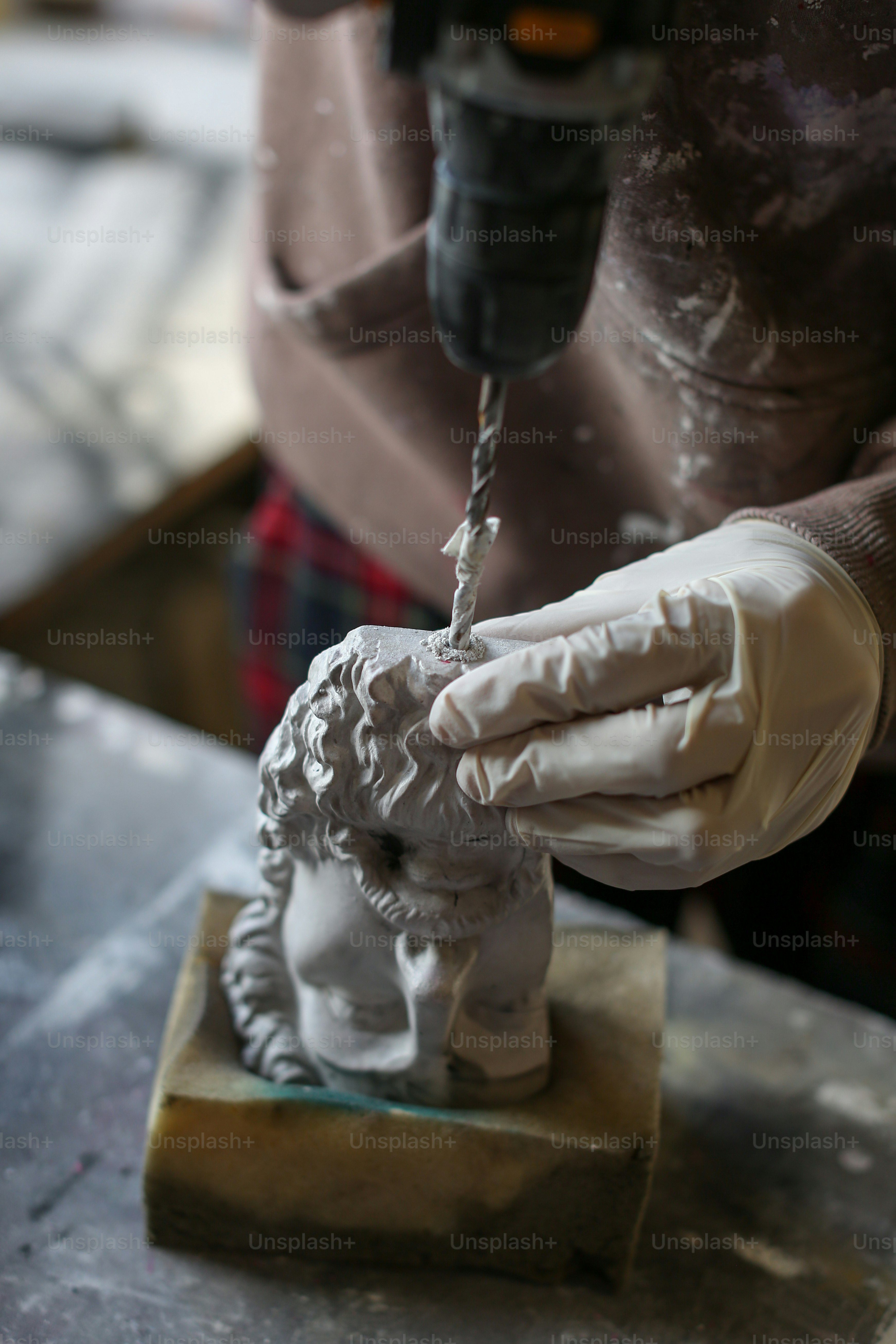 A statue being worked on with a drill photo – Artist Image on Unsplash