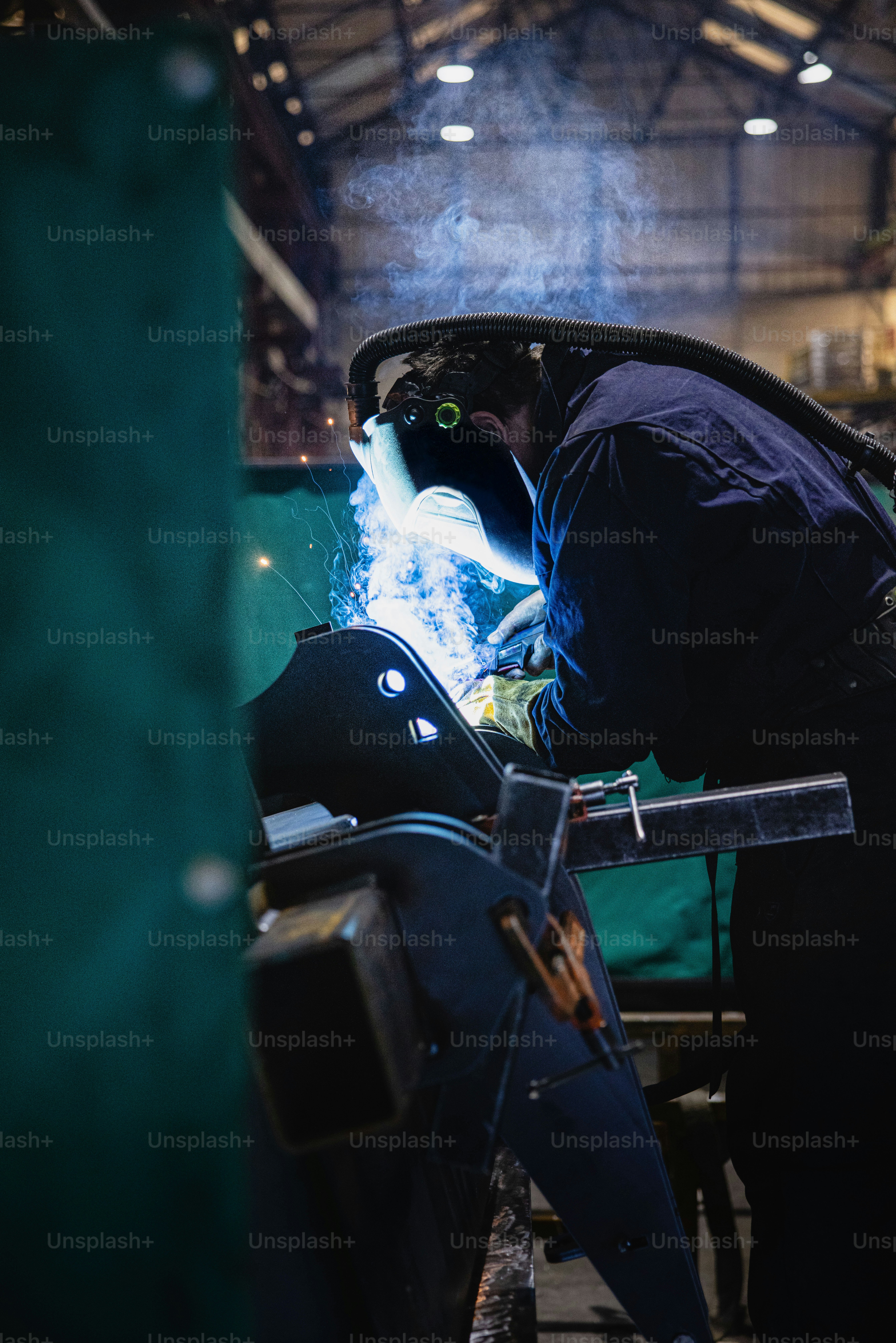 A welder working on a piece of metal photo – Metal work Image on Unsplash