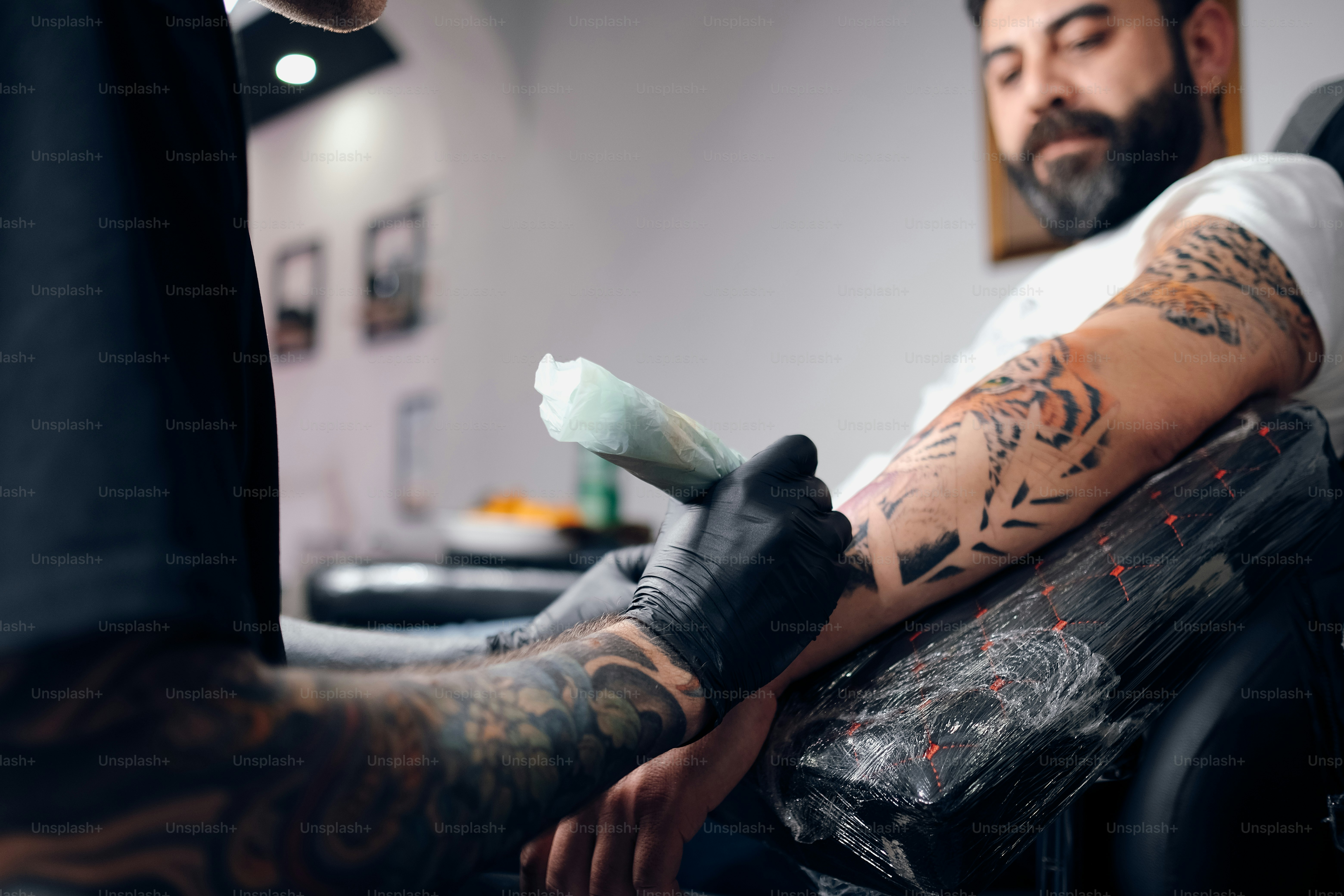 A man getting a tattoo on his arm photo – Tattooist Image on Unsplash