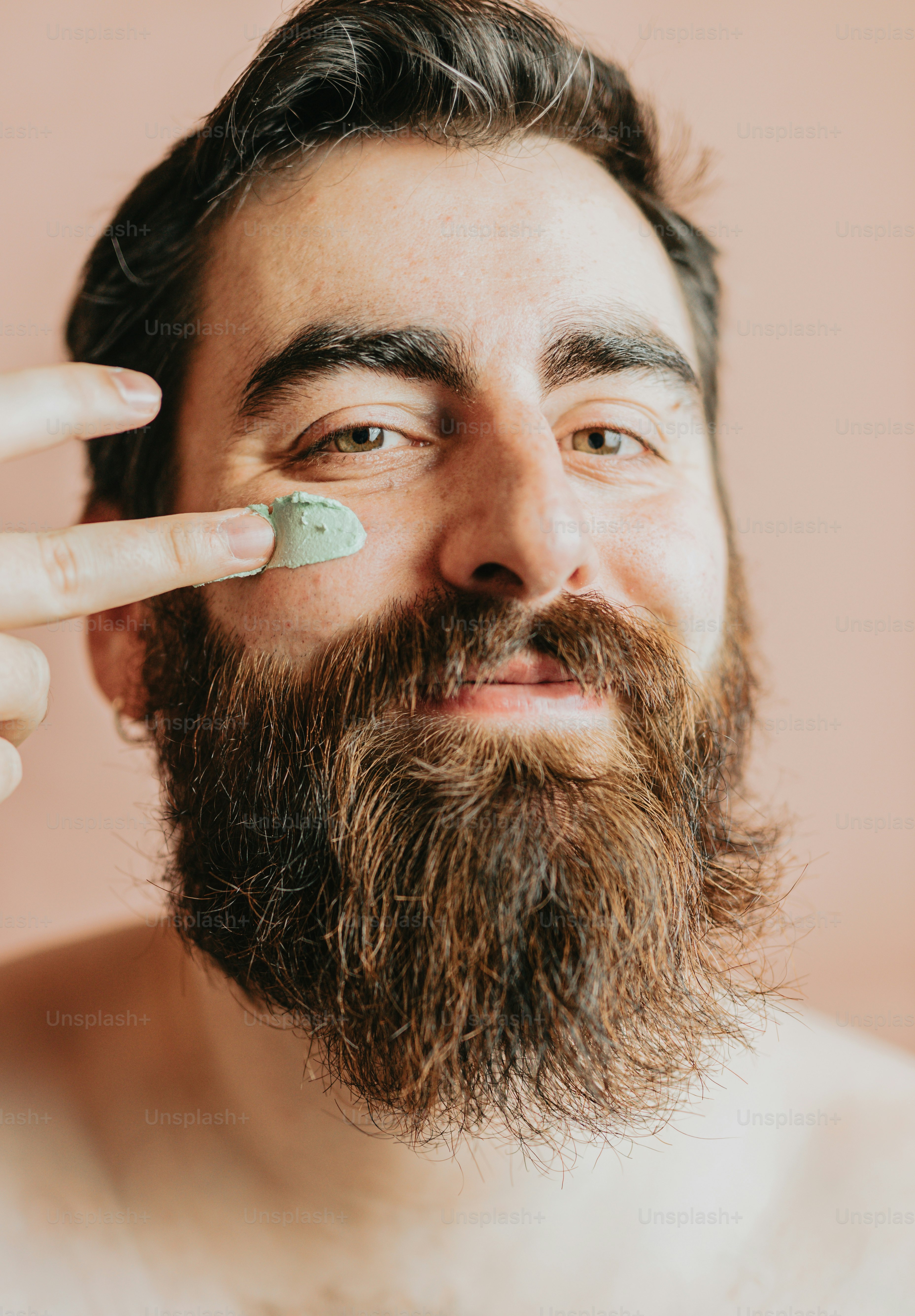 A man with a beard holding a piece of paper in his hand photo – Face ...