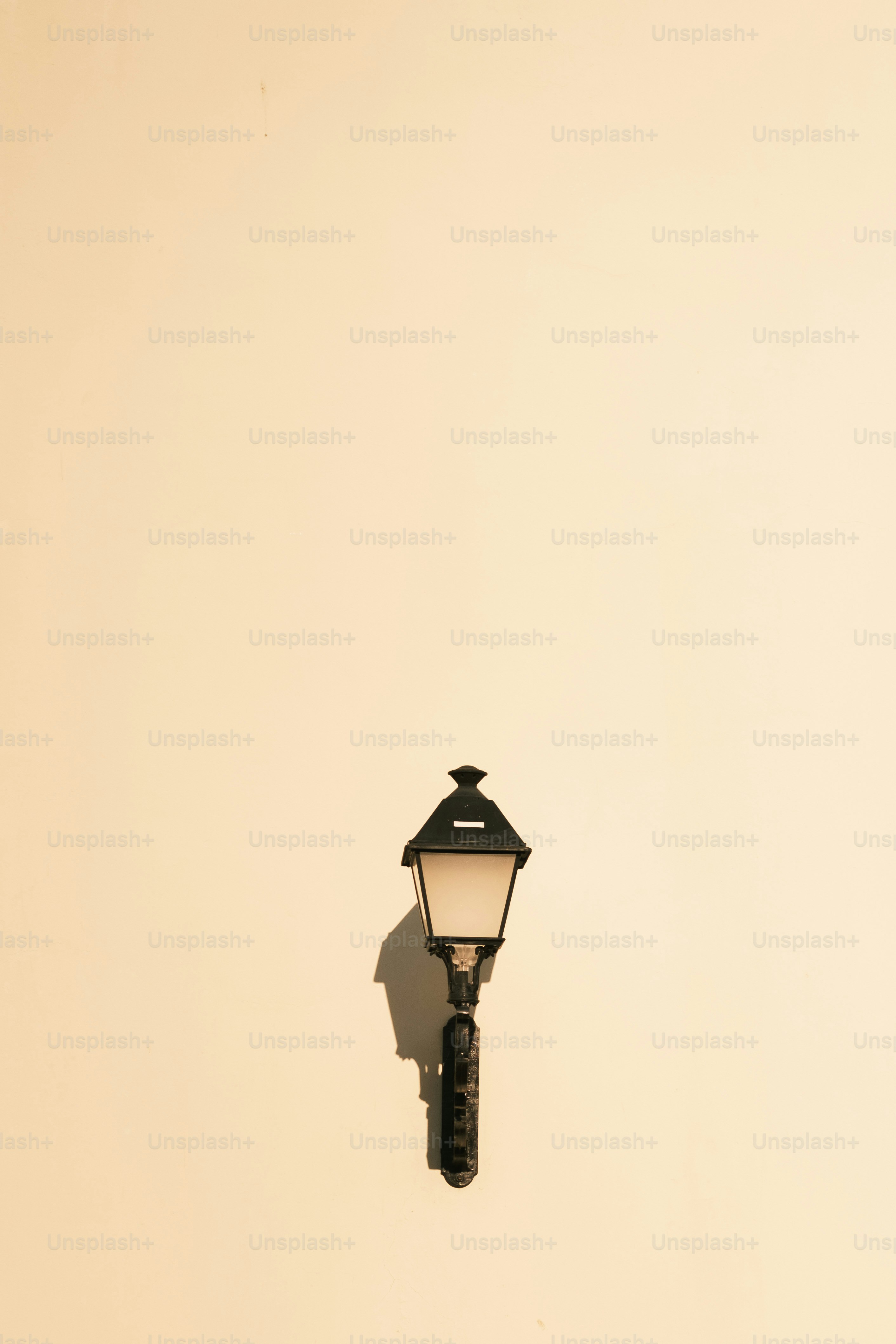 A street light on the side of a wall photo – Lamp post Image on Unsplash
