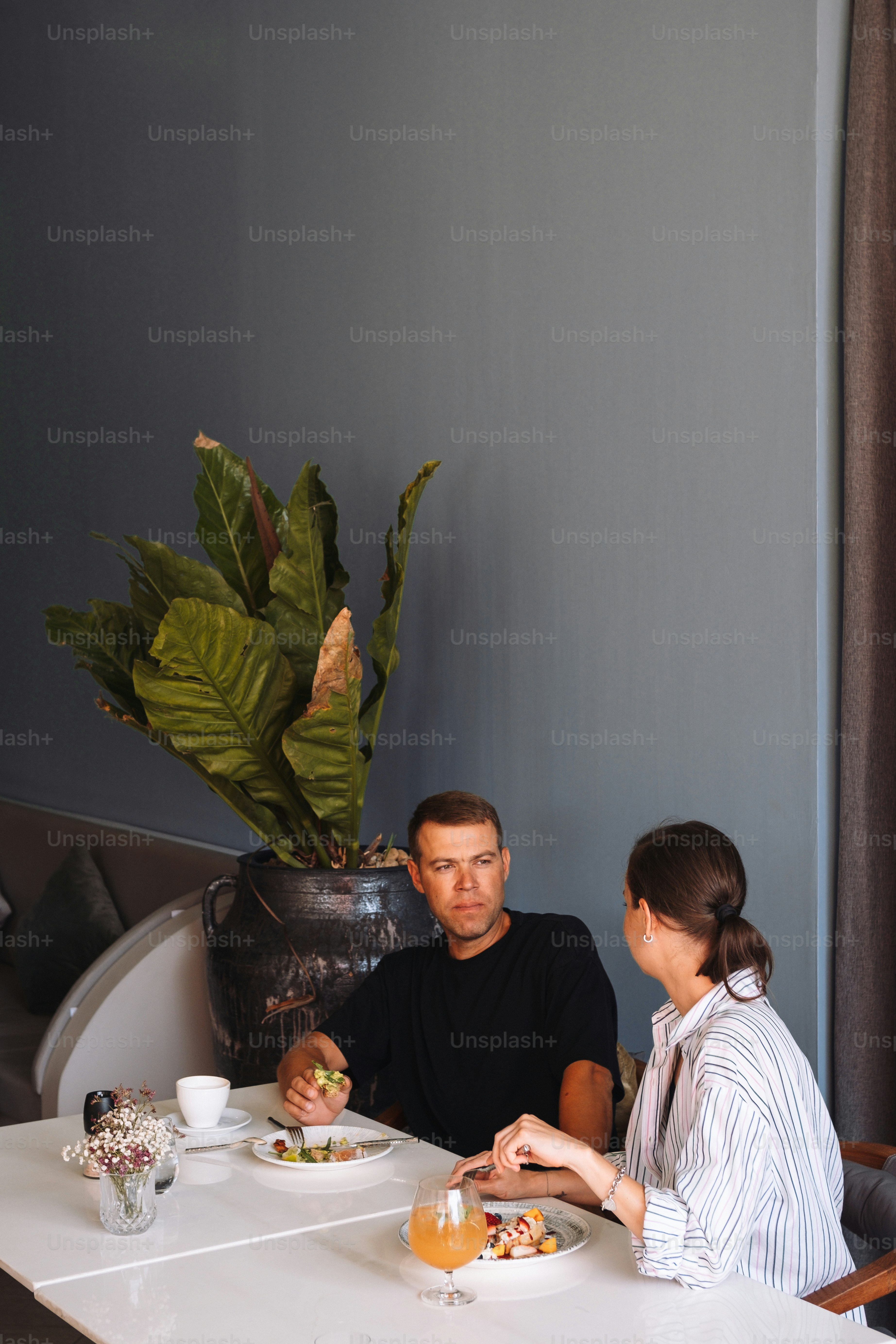 Eine Frau sitzt an einem Tisch mit einem Teller Essen Foto – Bild zum ...
