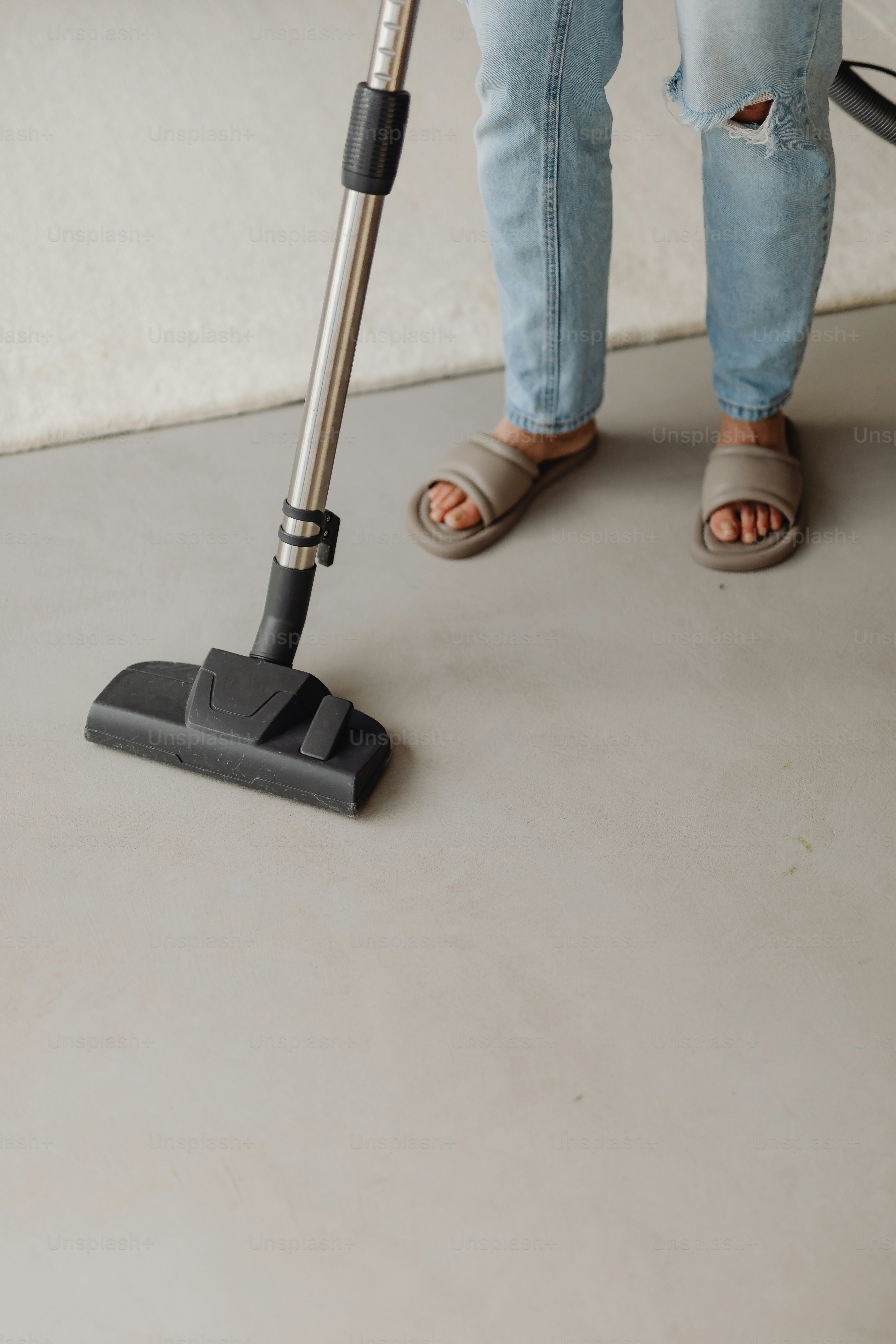 A person using a vacuum to clean a floor photo – Tidying up Image on ...