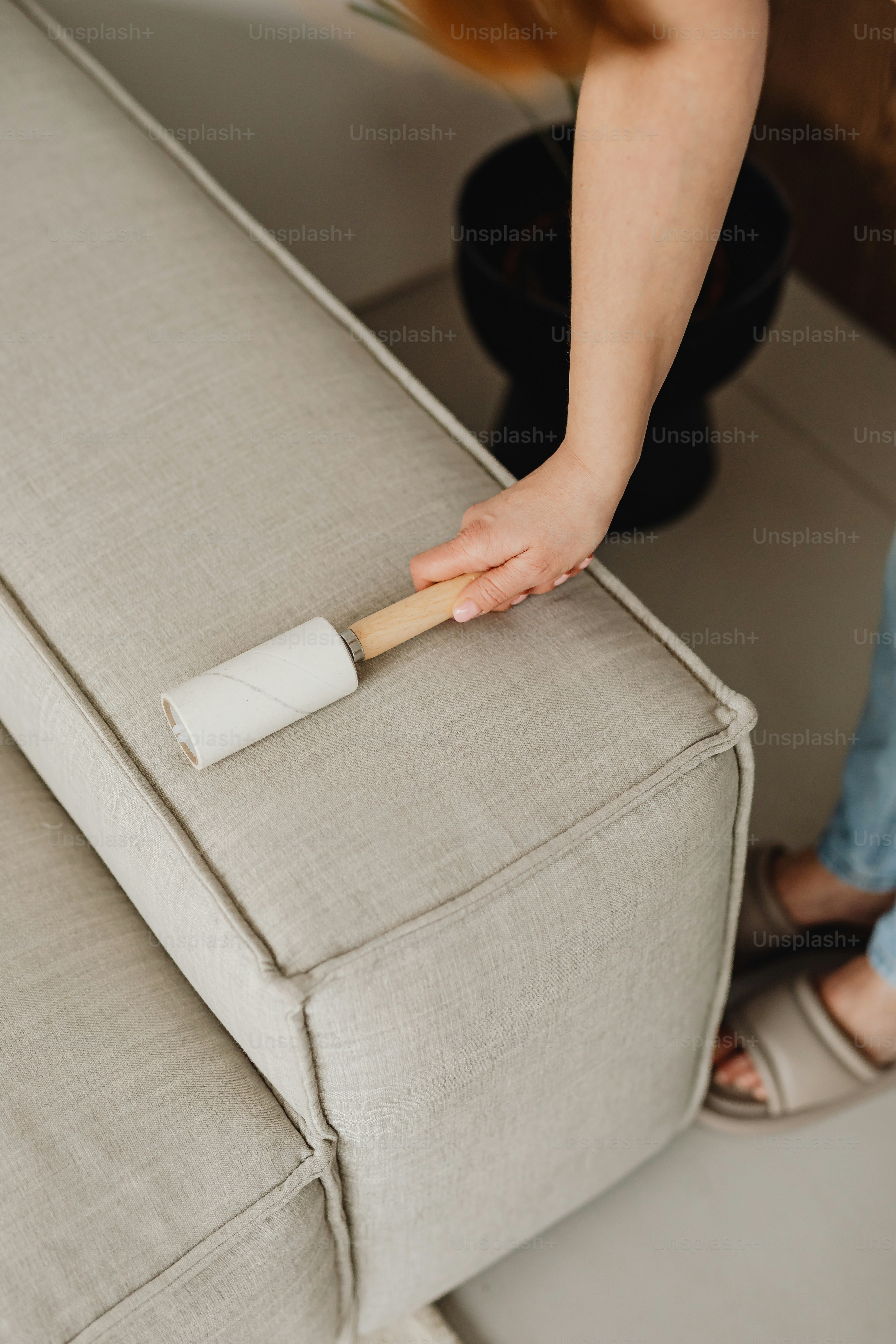A woman is cleaning a couch with a brush photo – Cleaning Image on Unsplash