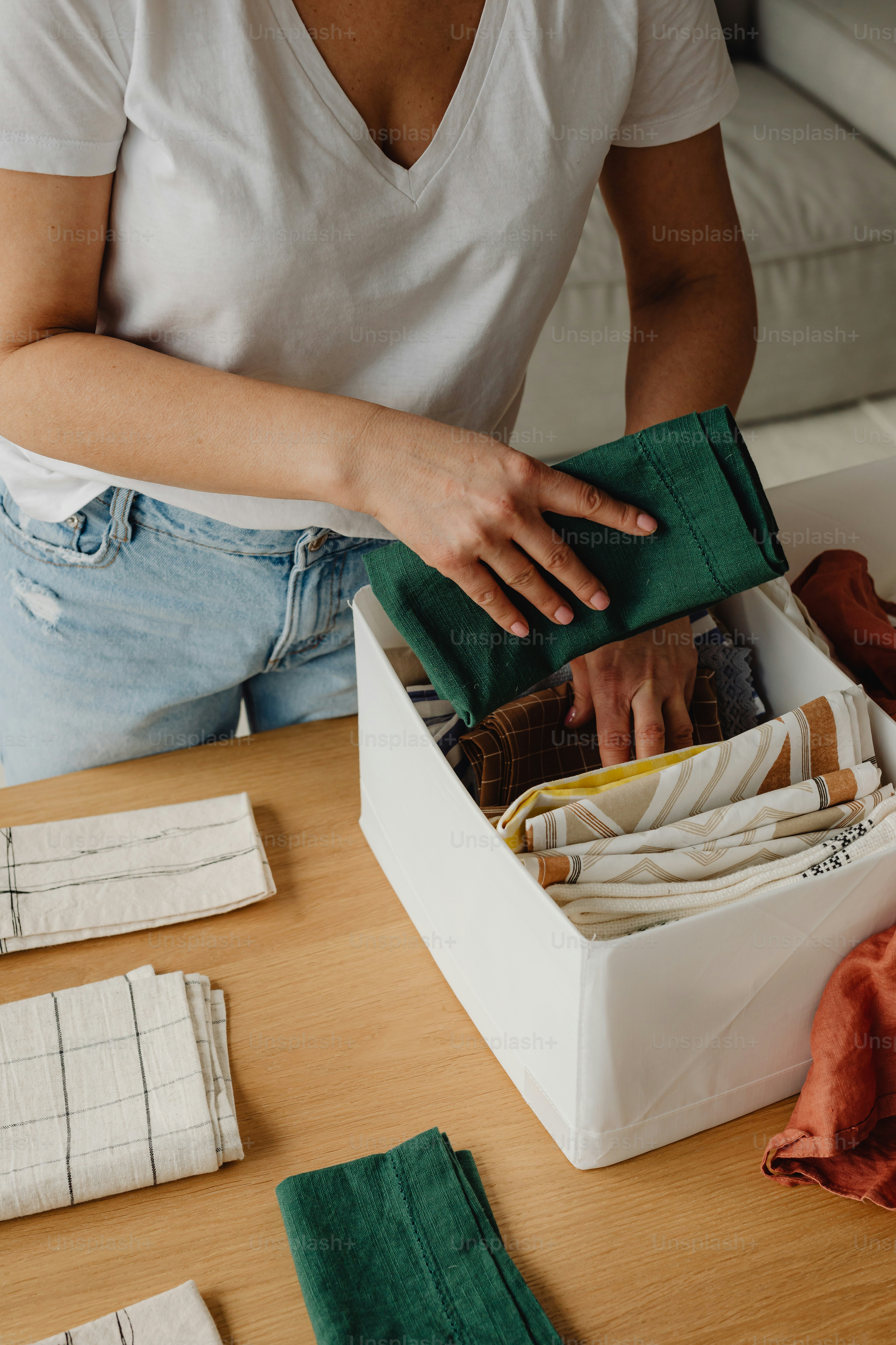 A woman is putting her clothes in a box photo – Tidying up Image on ...