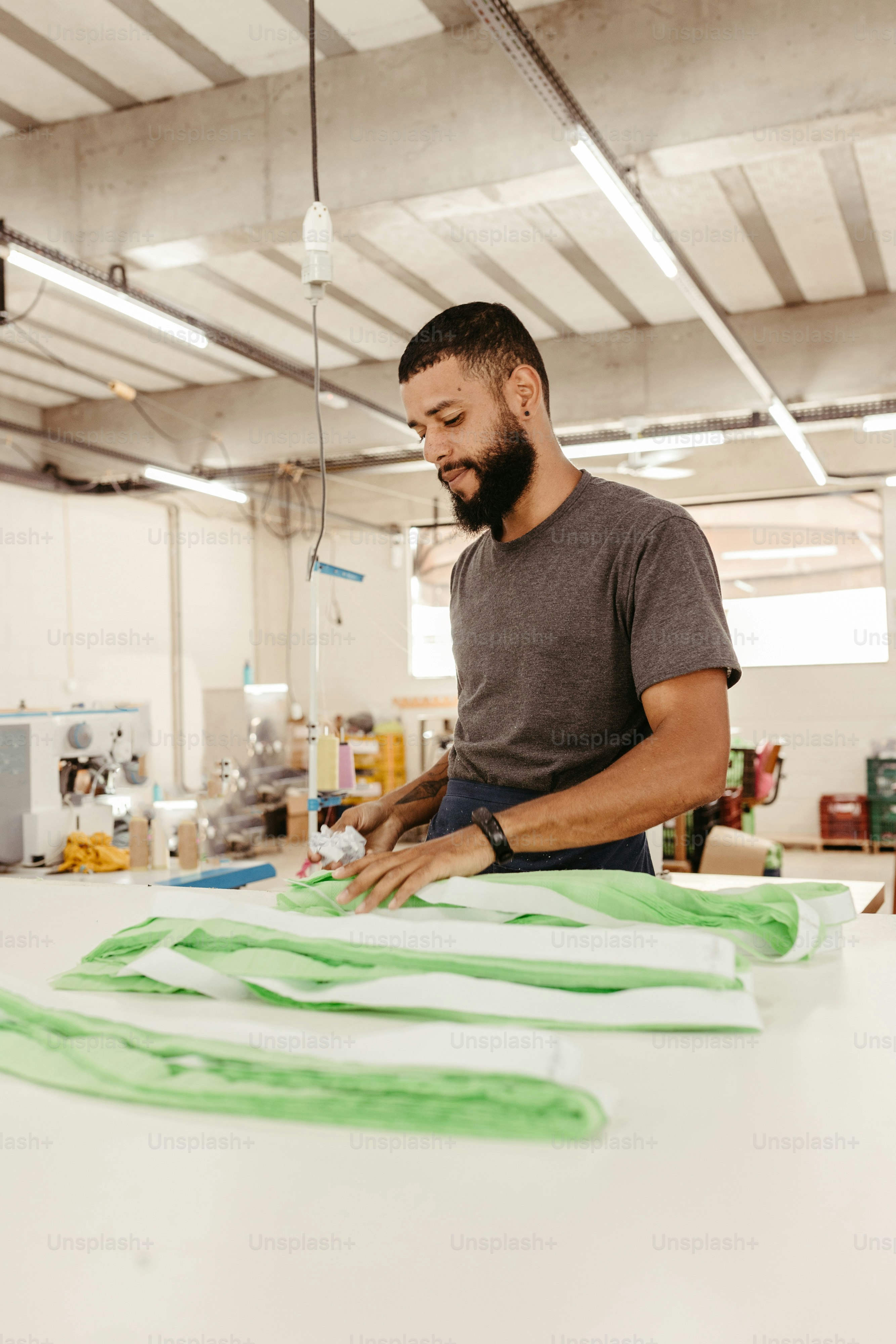 A man standing over a table cutting green ribbon photo – Tailor Image ...