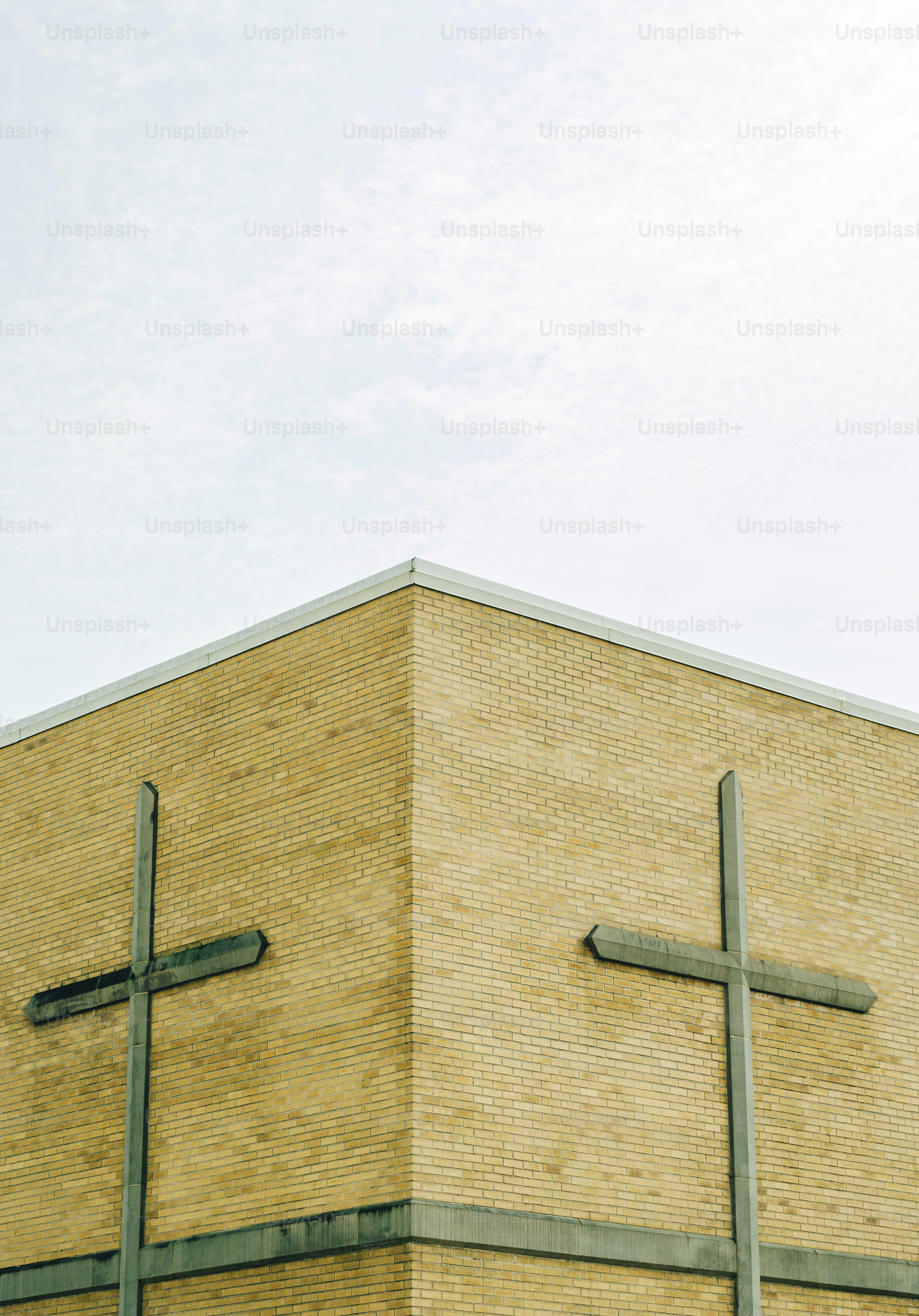 A large brick building with three crosses on it photo – Church cross ...