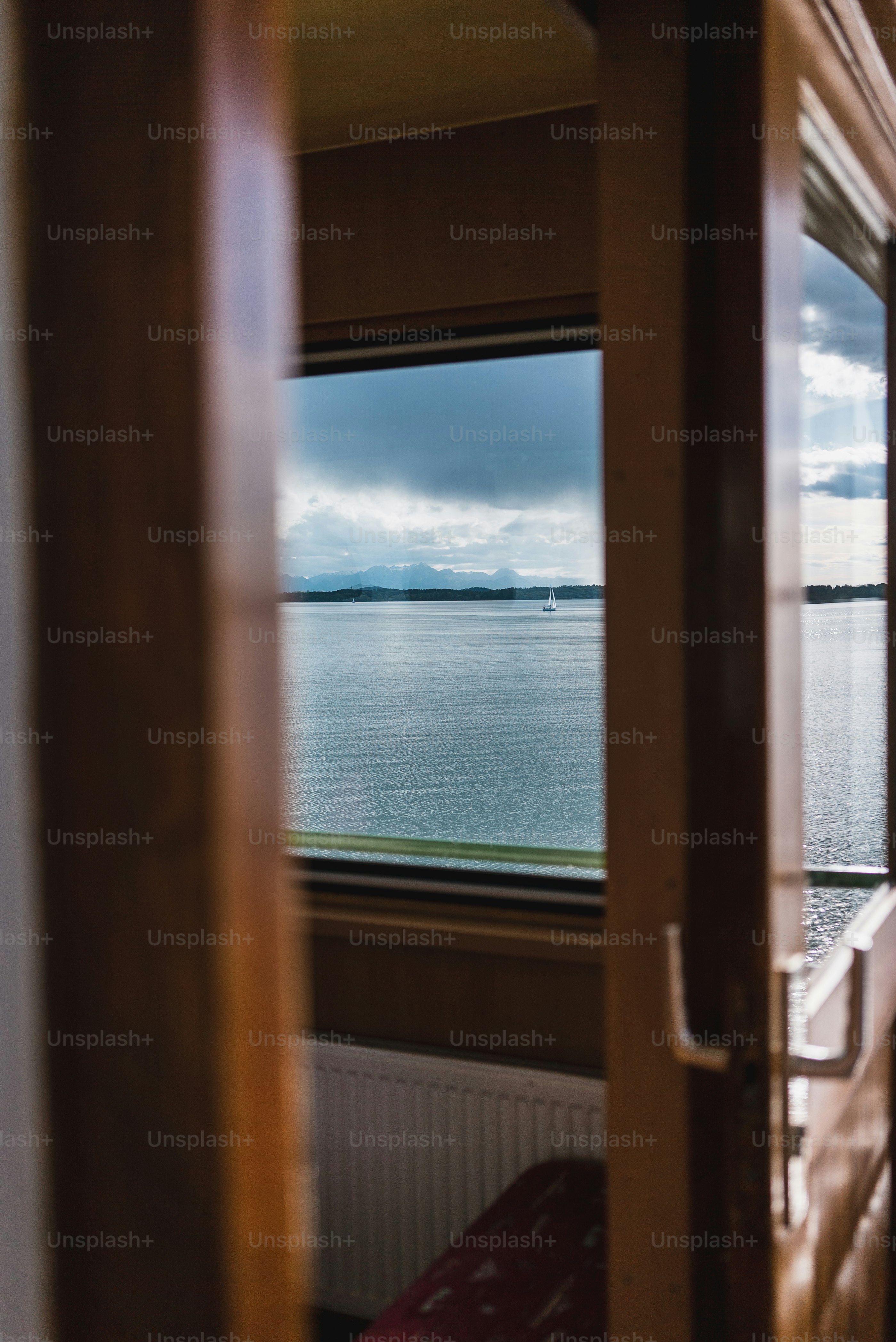 A window with a view of a lake and mountains photo – Transportation ...