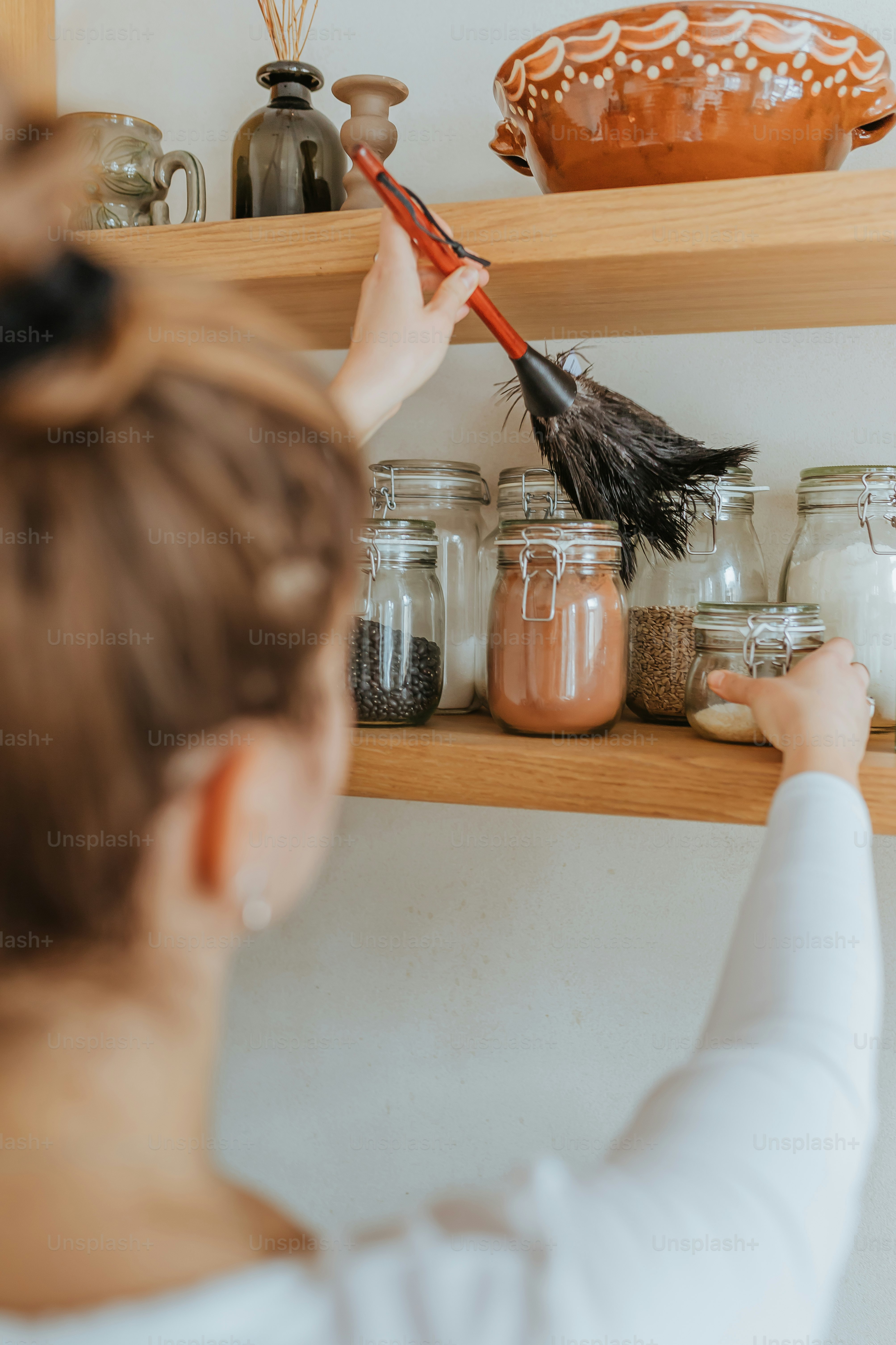A woman is cleaning jars with a broom photo – Cleaning Image on Unsplash