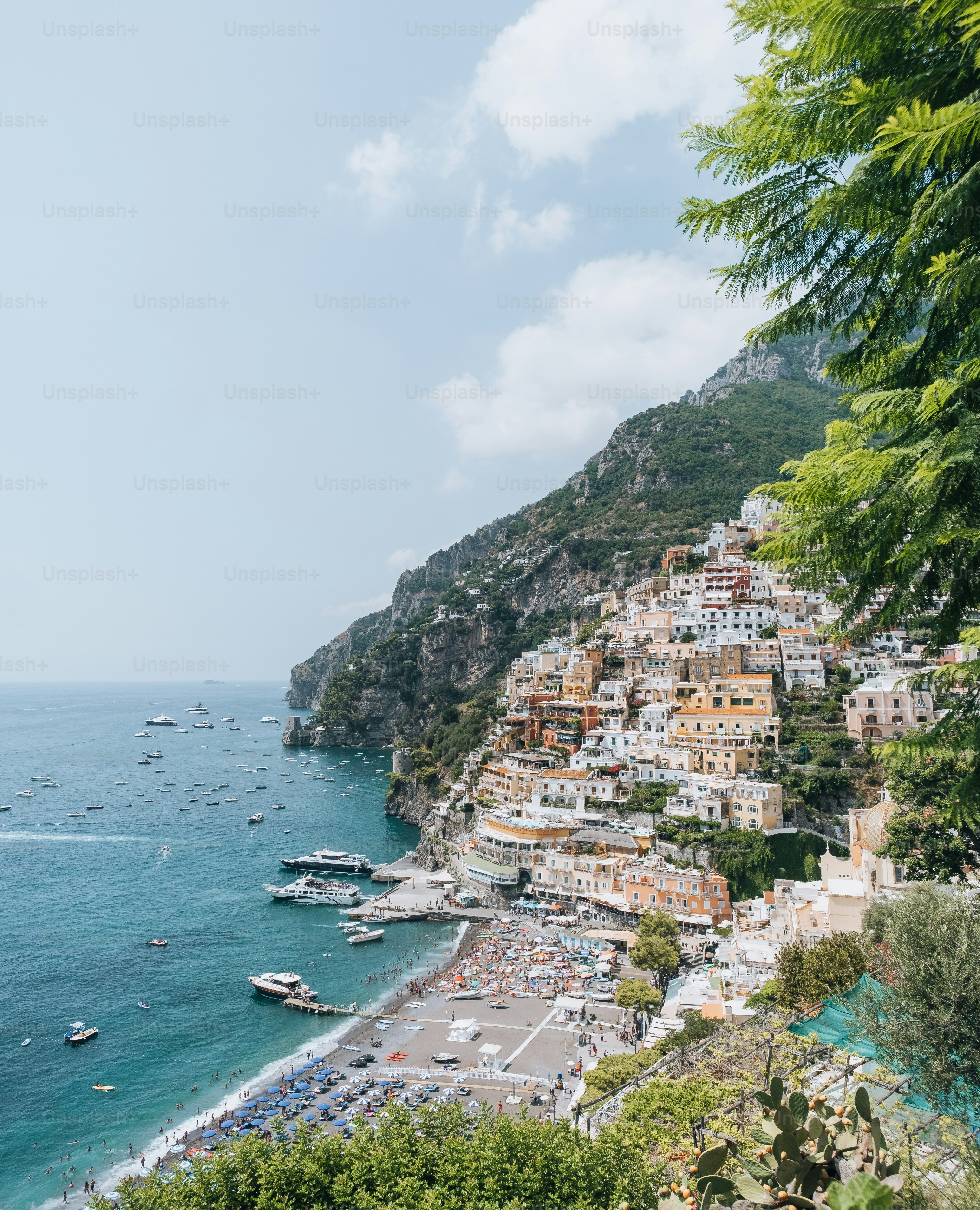 A view of a beach with boats in the water photo – Positano Image on ...