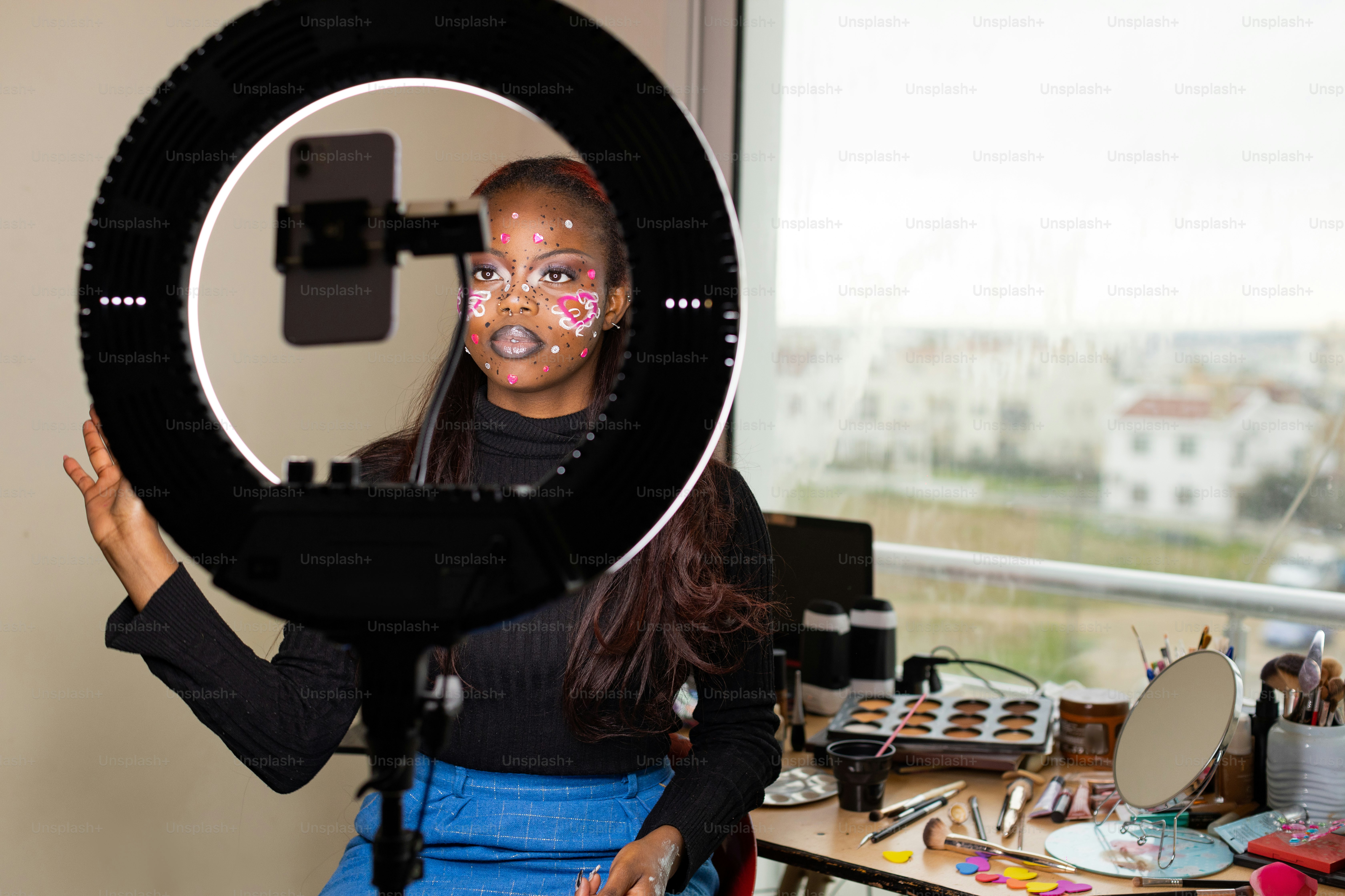 A woman with face paint is holding a camera photo – Influencer Image on ...